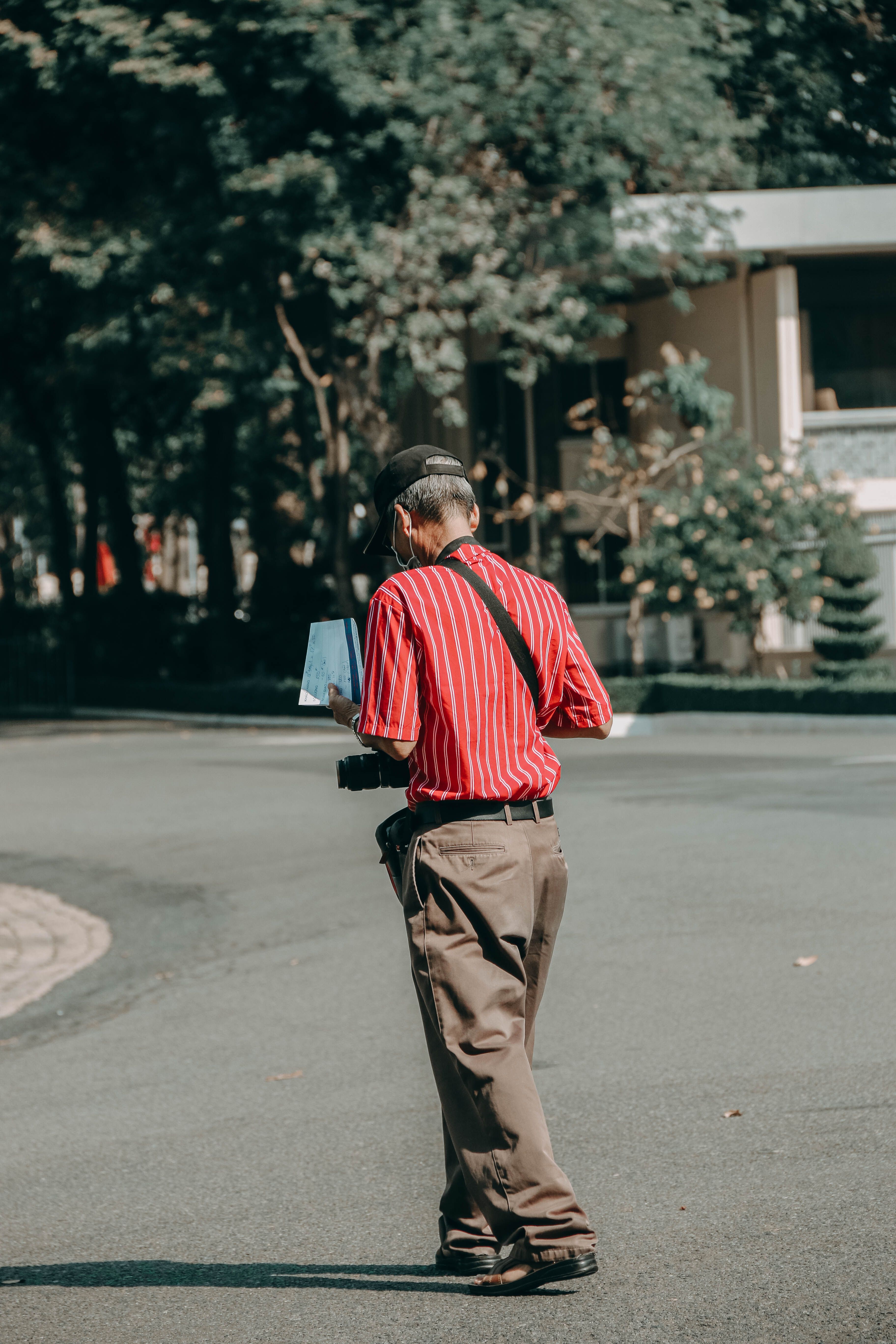Man with camera walking down street · Free Stock Photo