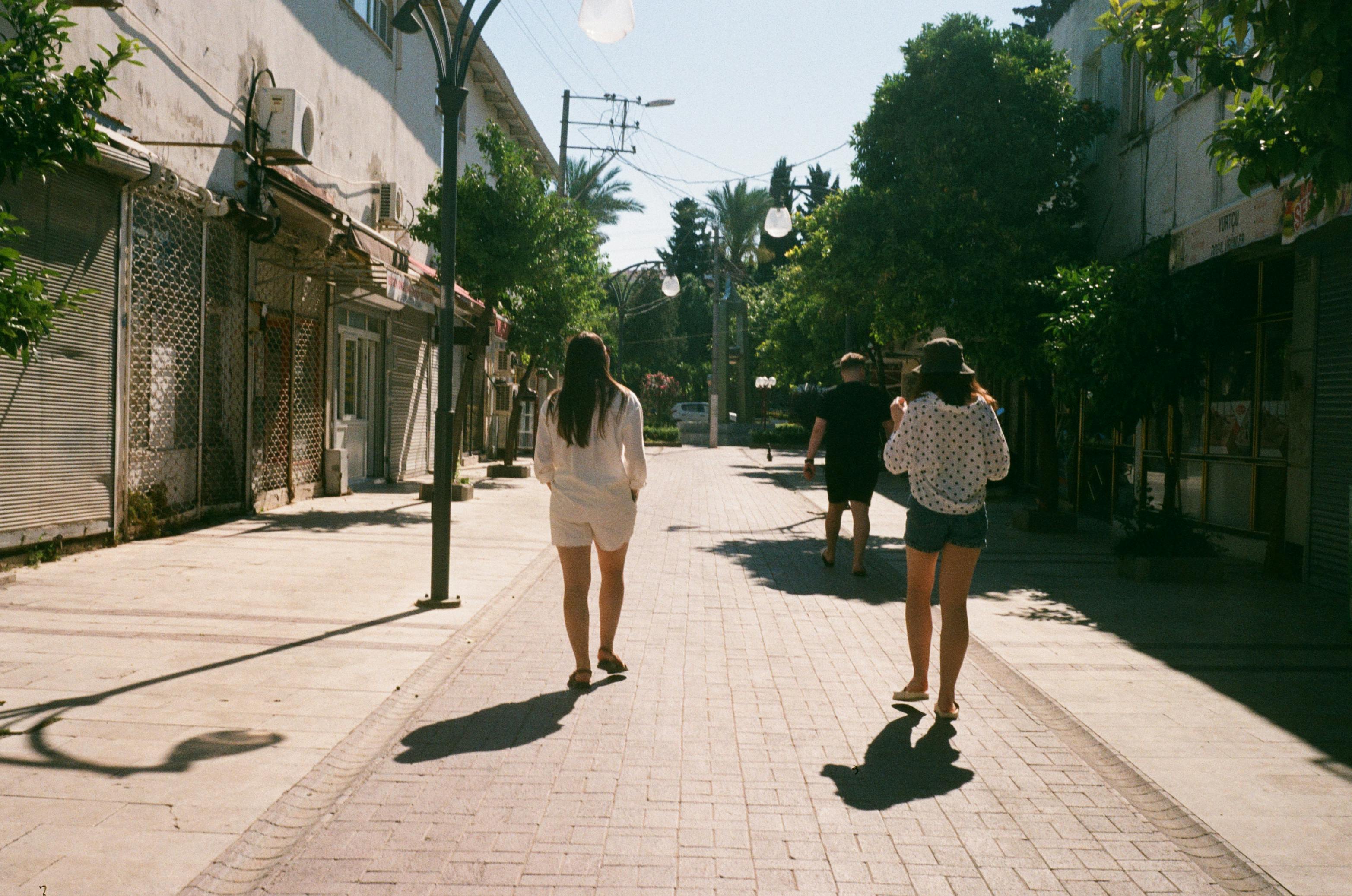 Back View of a Woman Walking Near Buildings · Free Stock Photo
