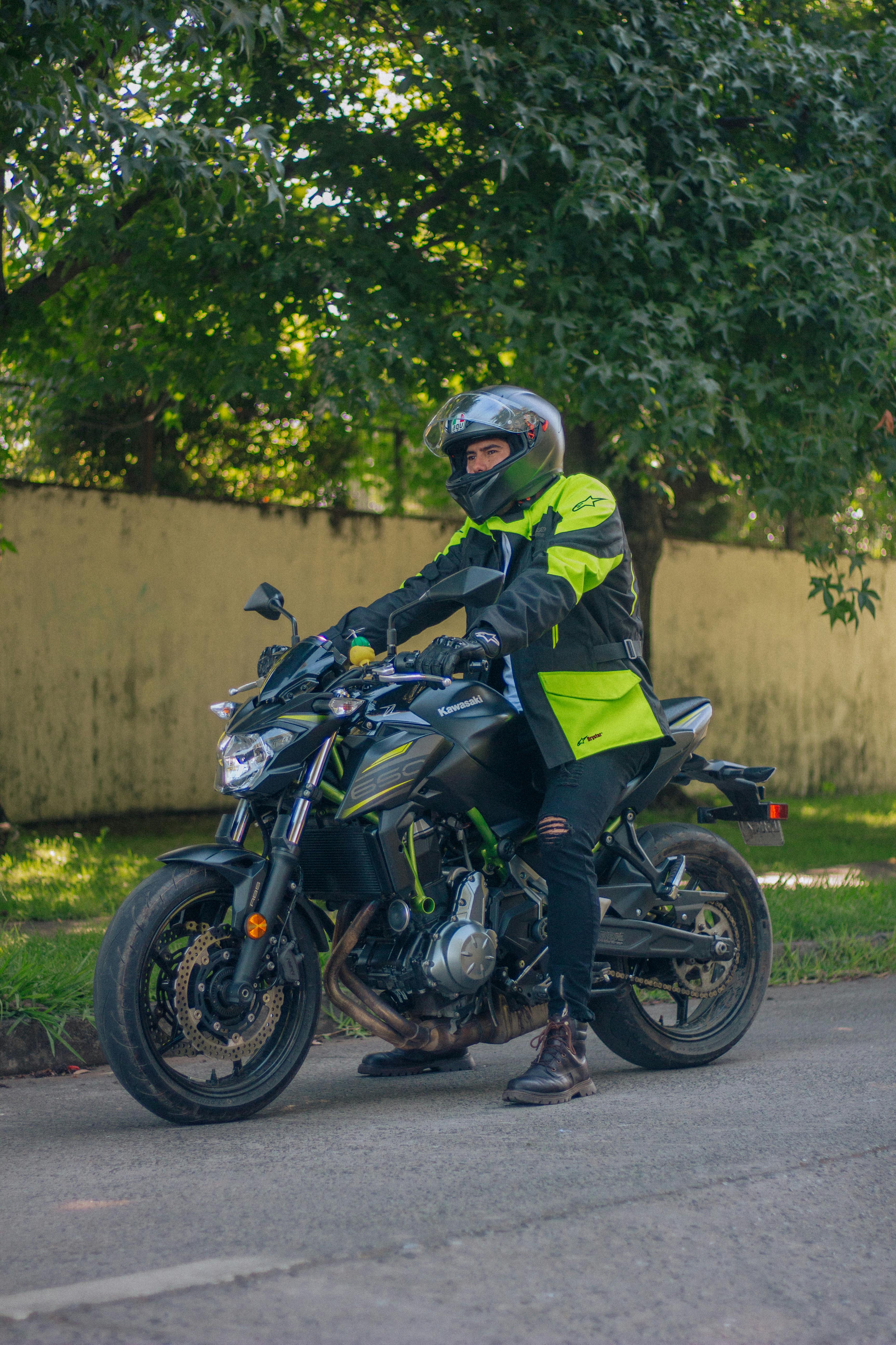 Man in Black and Green Jacket Riding Motorcycle · Free Stock Photo