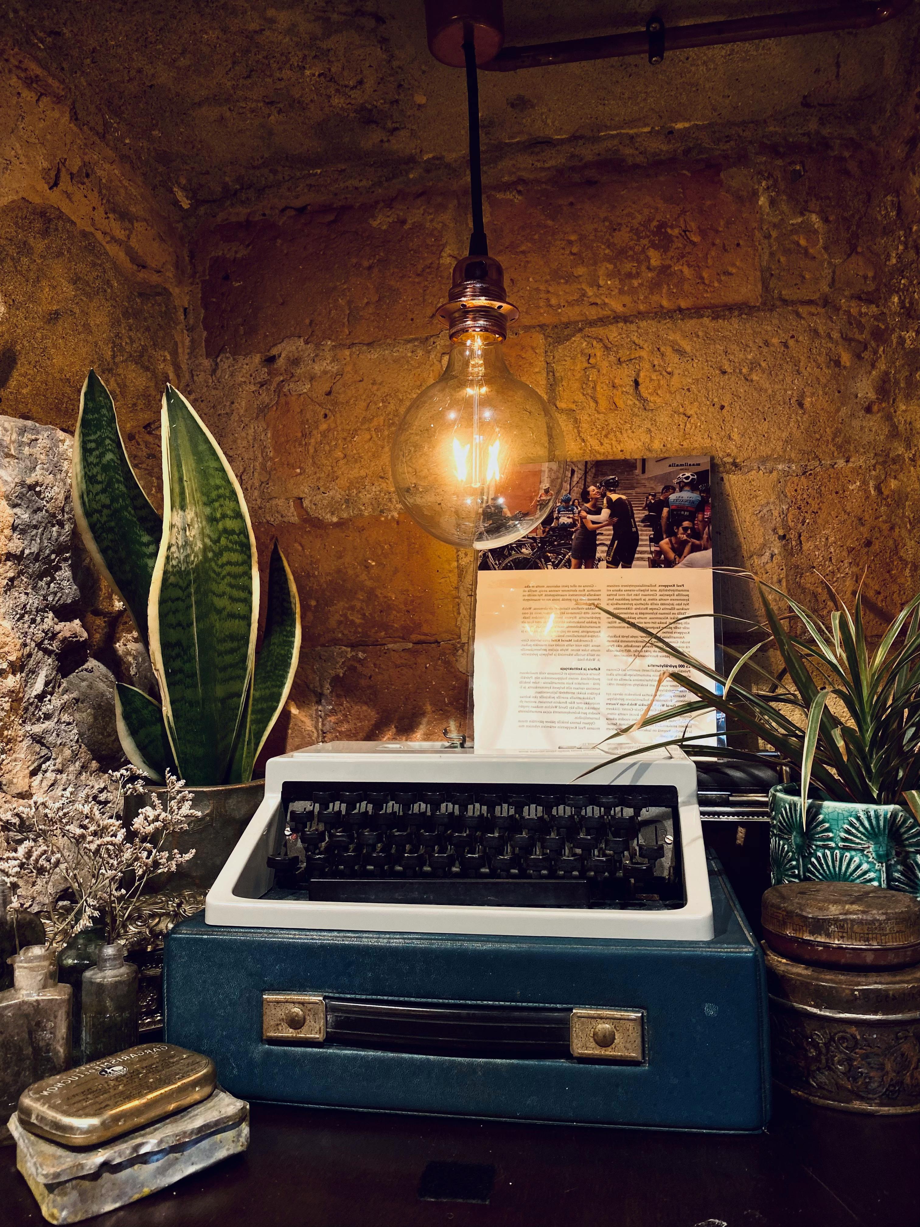 Photo of a Typewriter Near a Light Bulb · Free Stock Photo