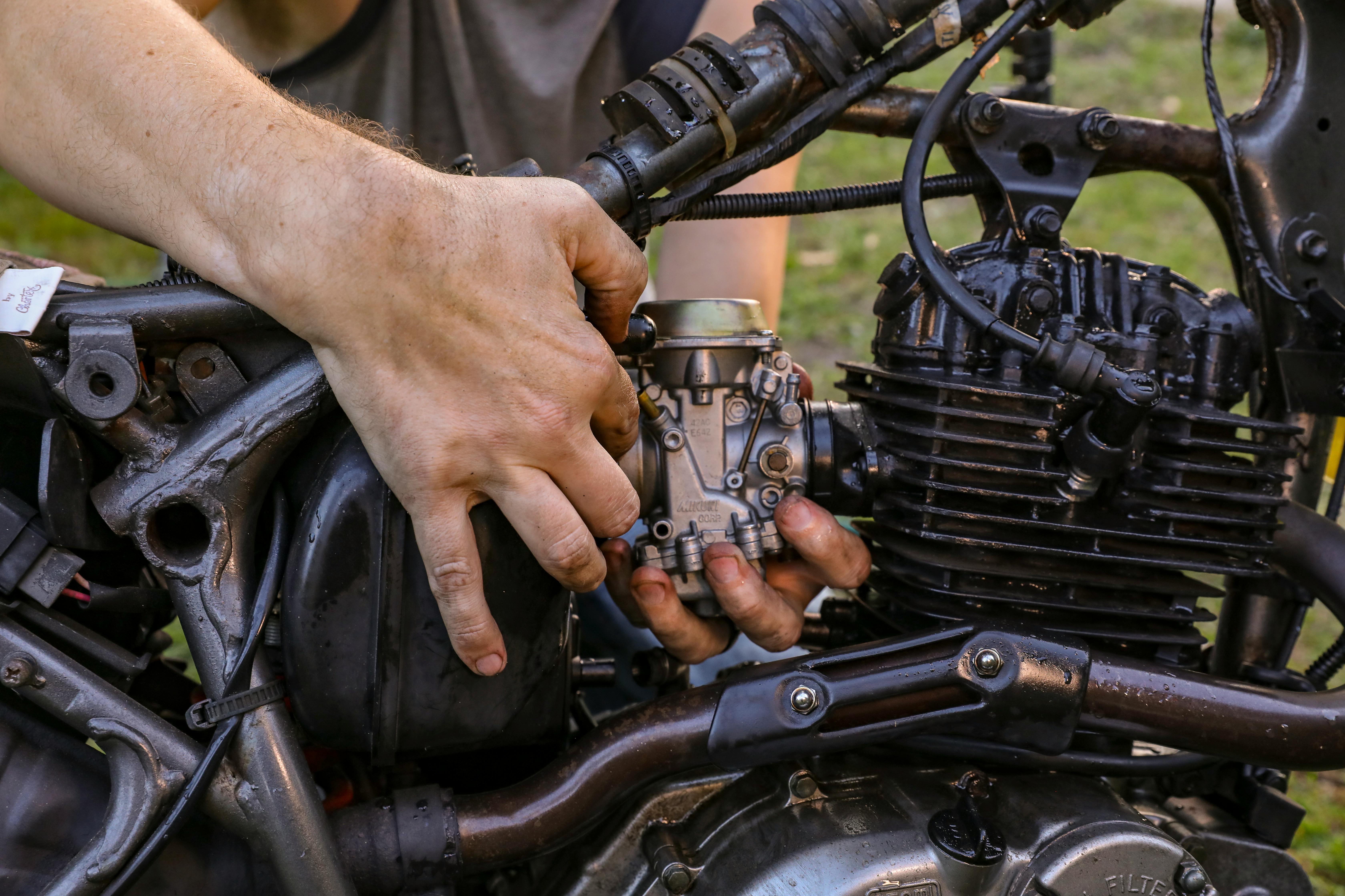 Close-Up Shot of a Person Fixing an Engine of a Motorcycle · Free Stock ...