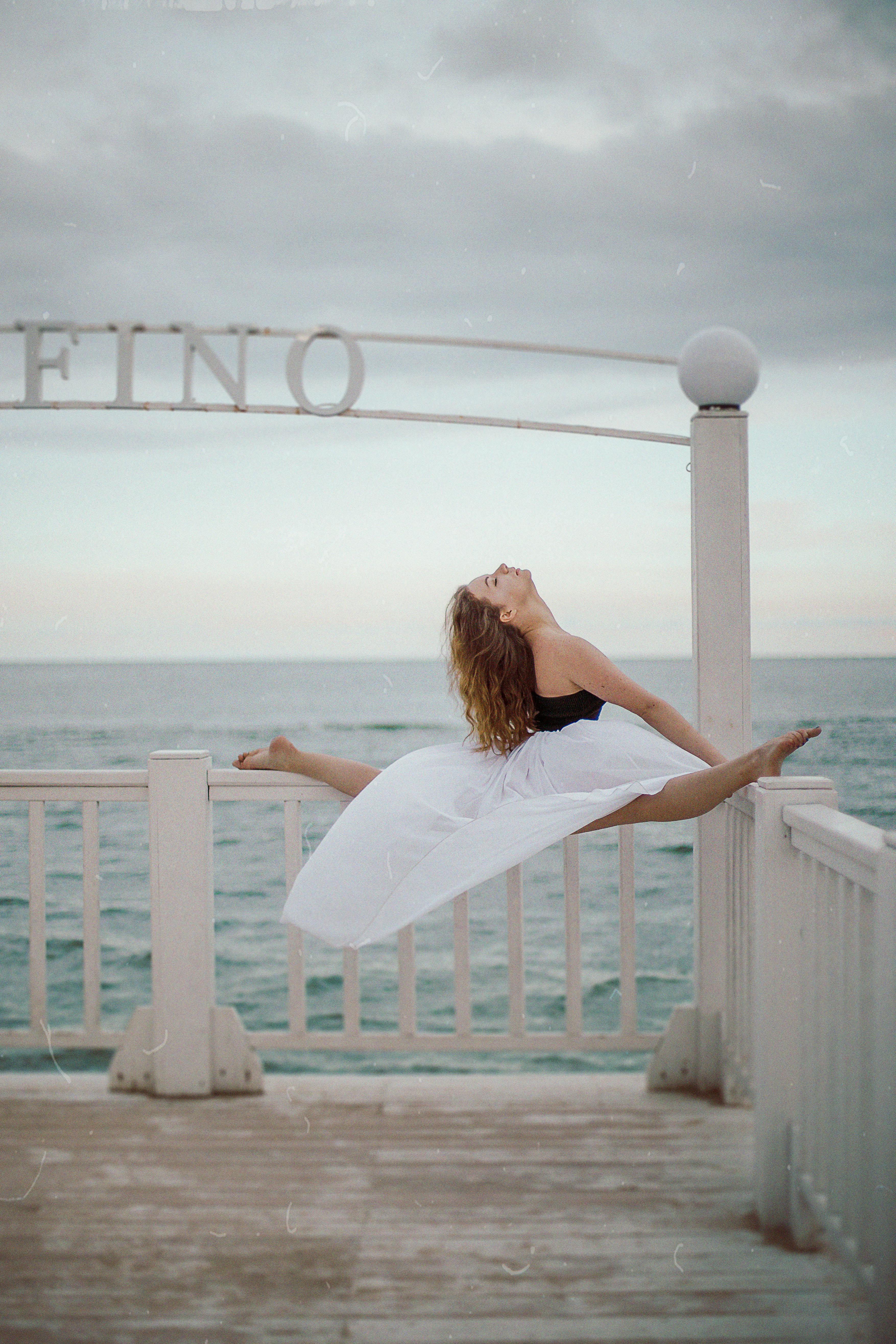 Woman Stretching Her Legs on Metal Railings · Free Stock Photo