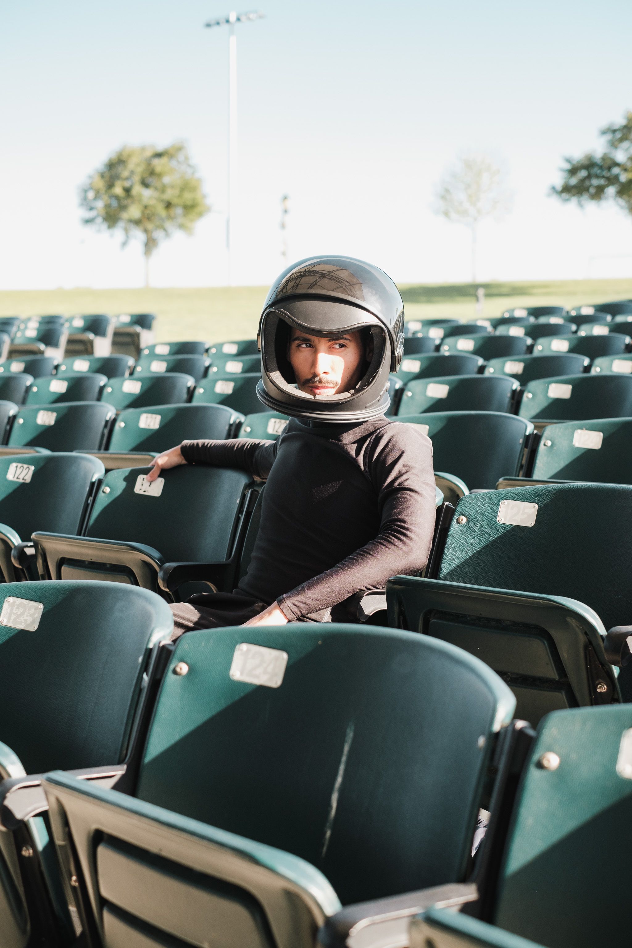 Photo of a Man Wearing a Helmet Sitting on Bleacher Chairs · Free Stock ...