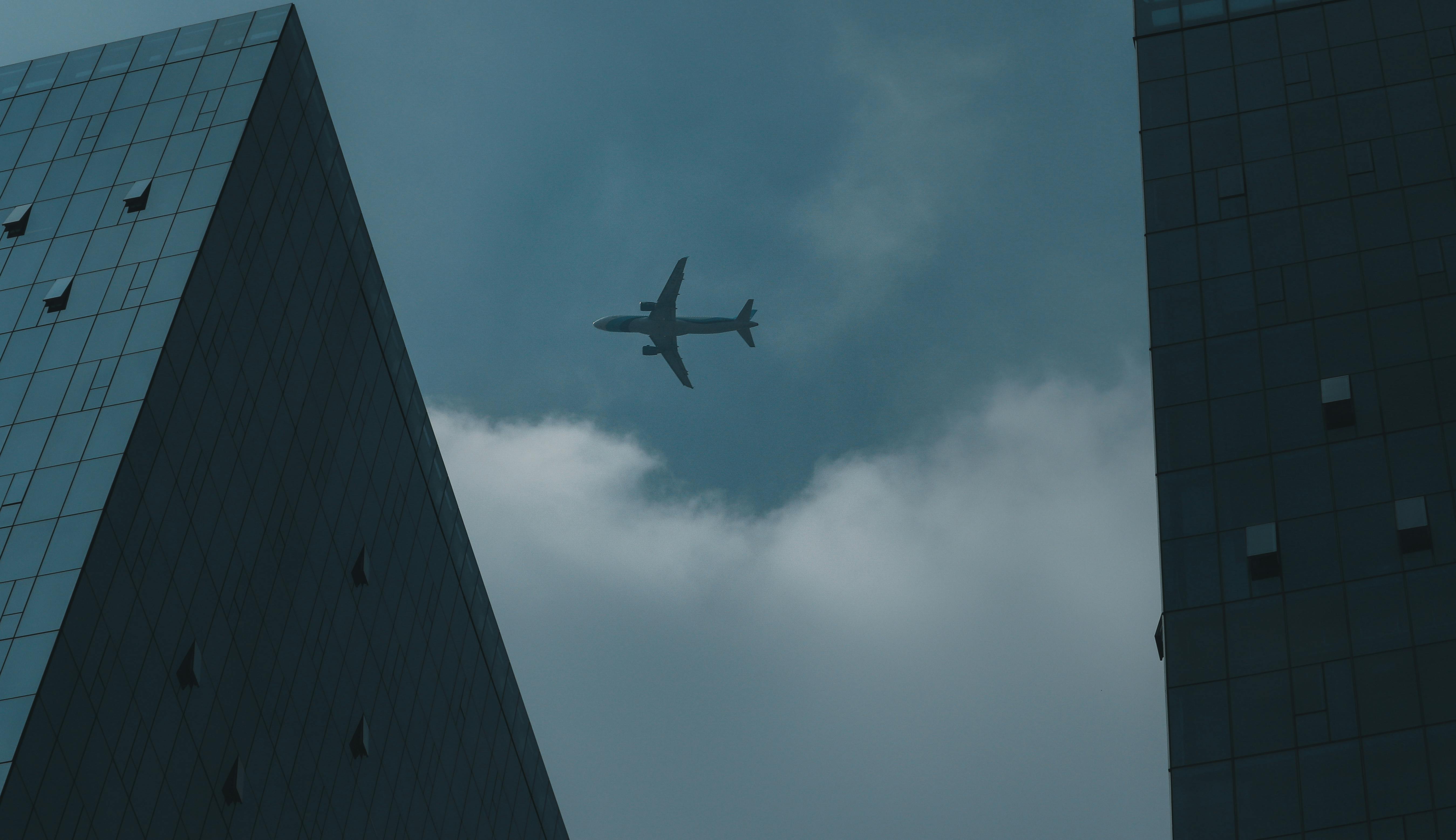 Airplane Flying above Buildings · Free Stock Photo