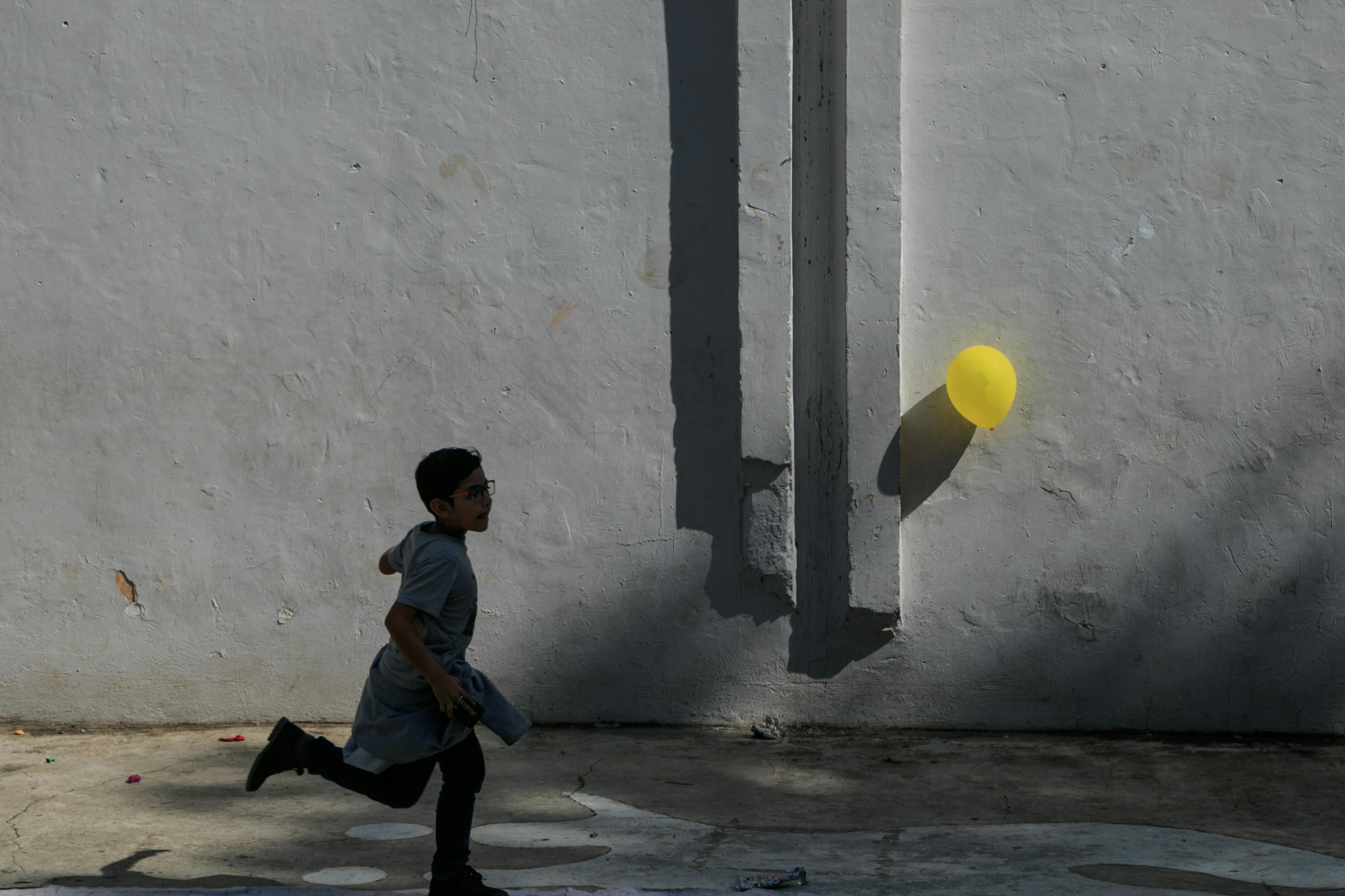 Child Chasing a Yellow Balloon · Free Stock Photo