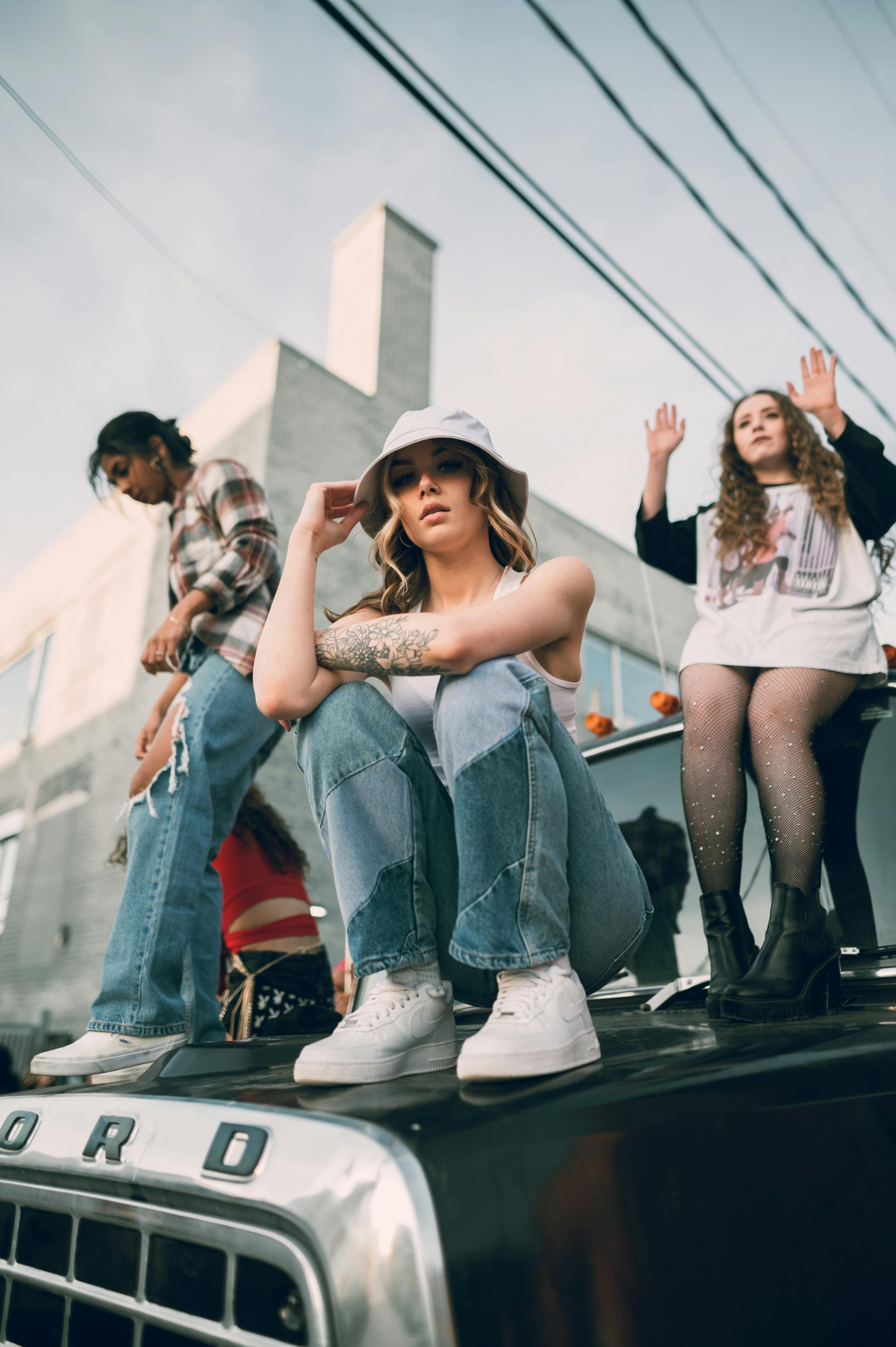 Girl in Bucket Hat Sitting on a Car Hood · Free Stock Photo
