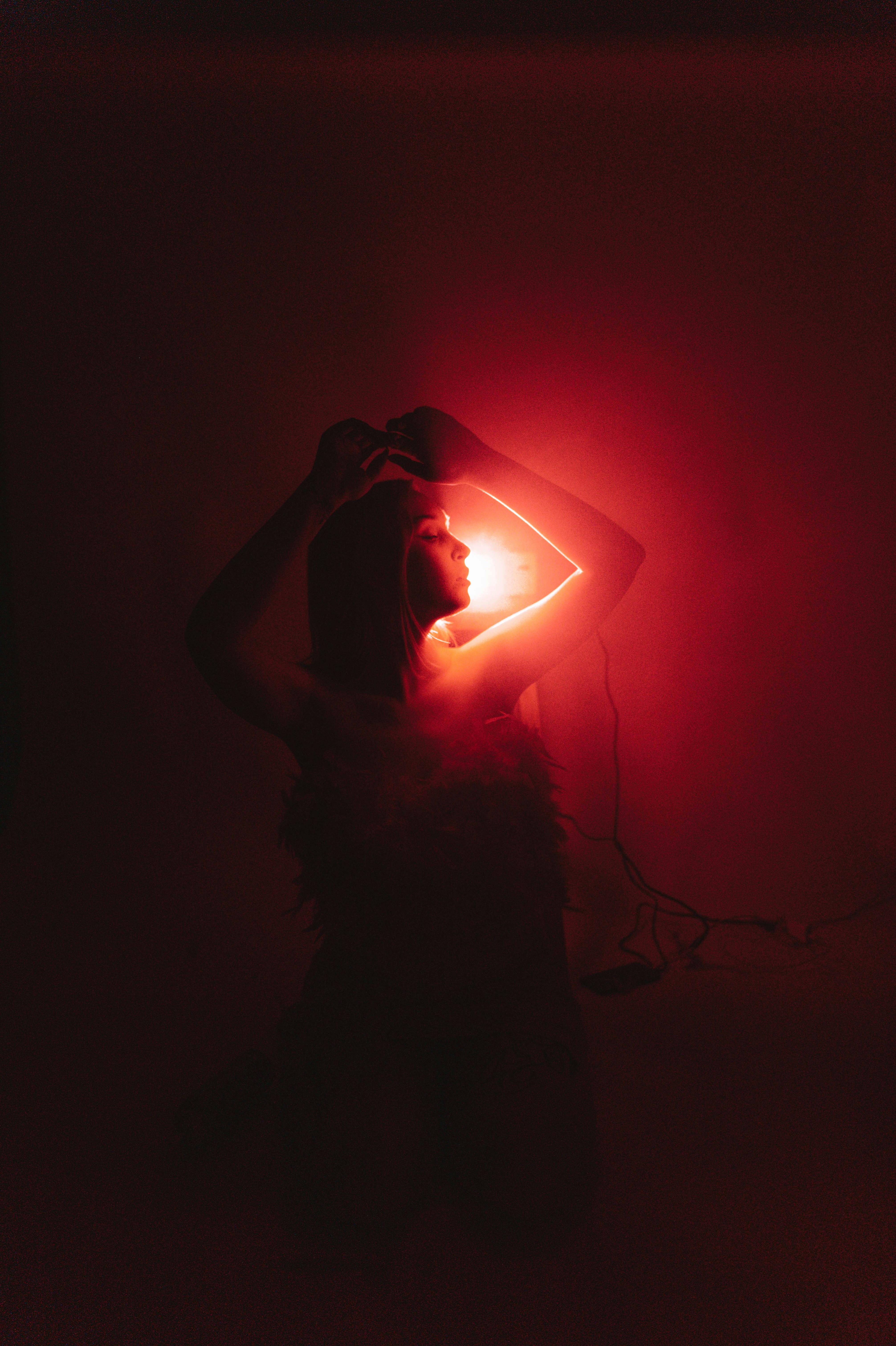 A Woman Posing Near a Red Light · Free Stock Photo