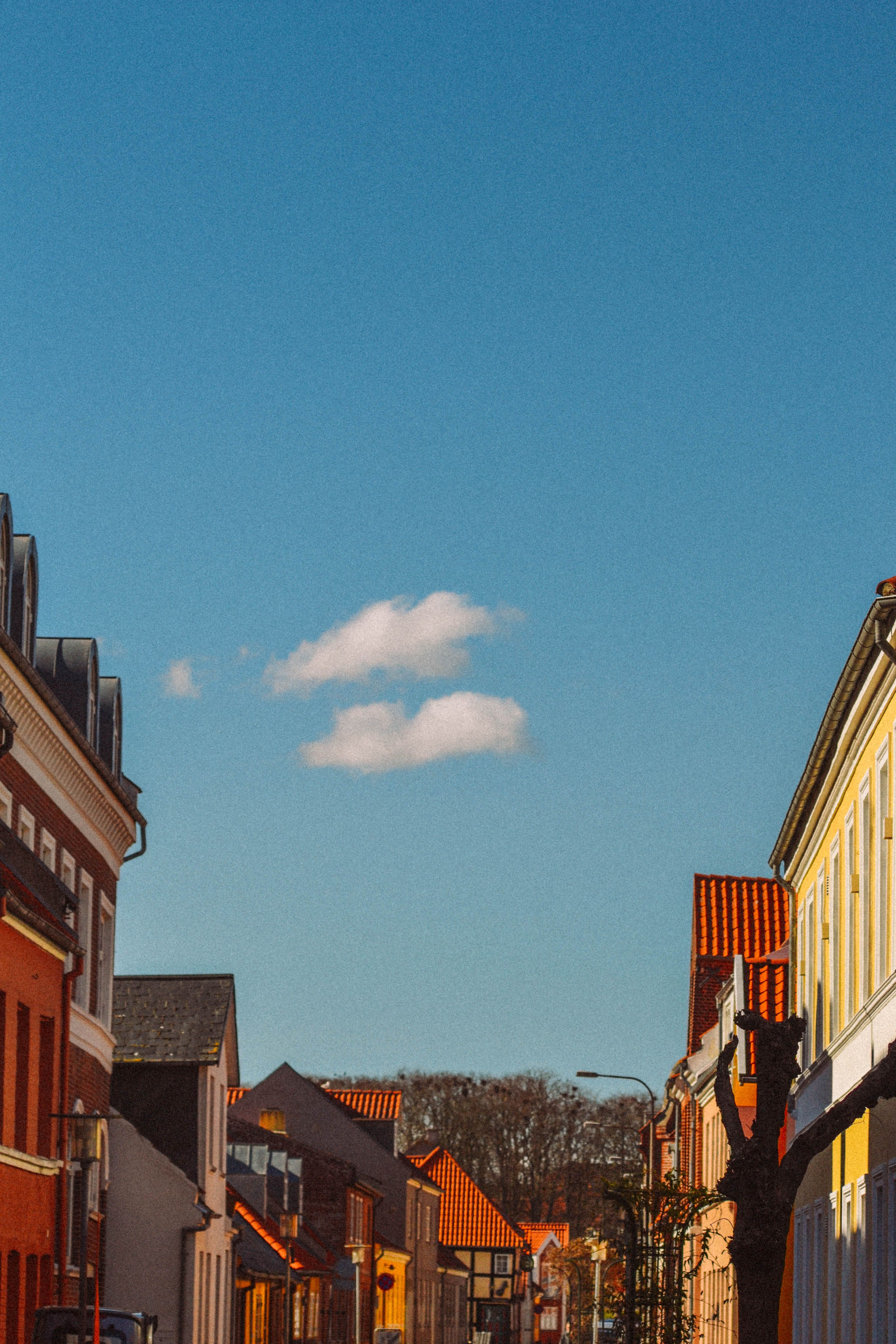 Blue Sky and Clouds over Buildings · Free Stock Photo