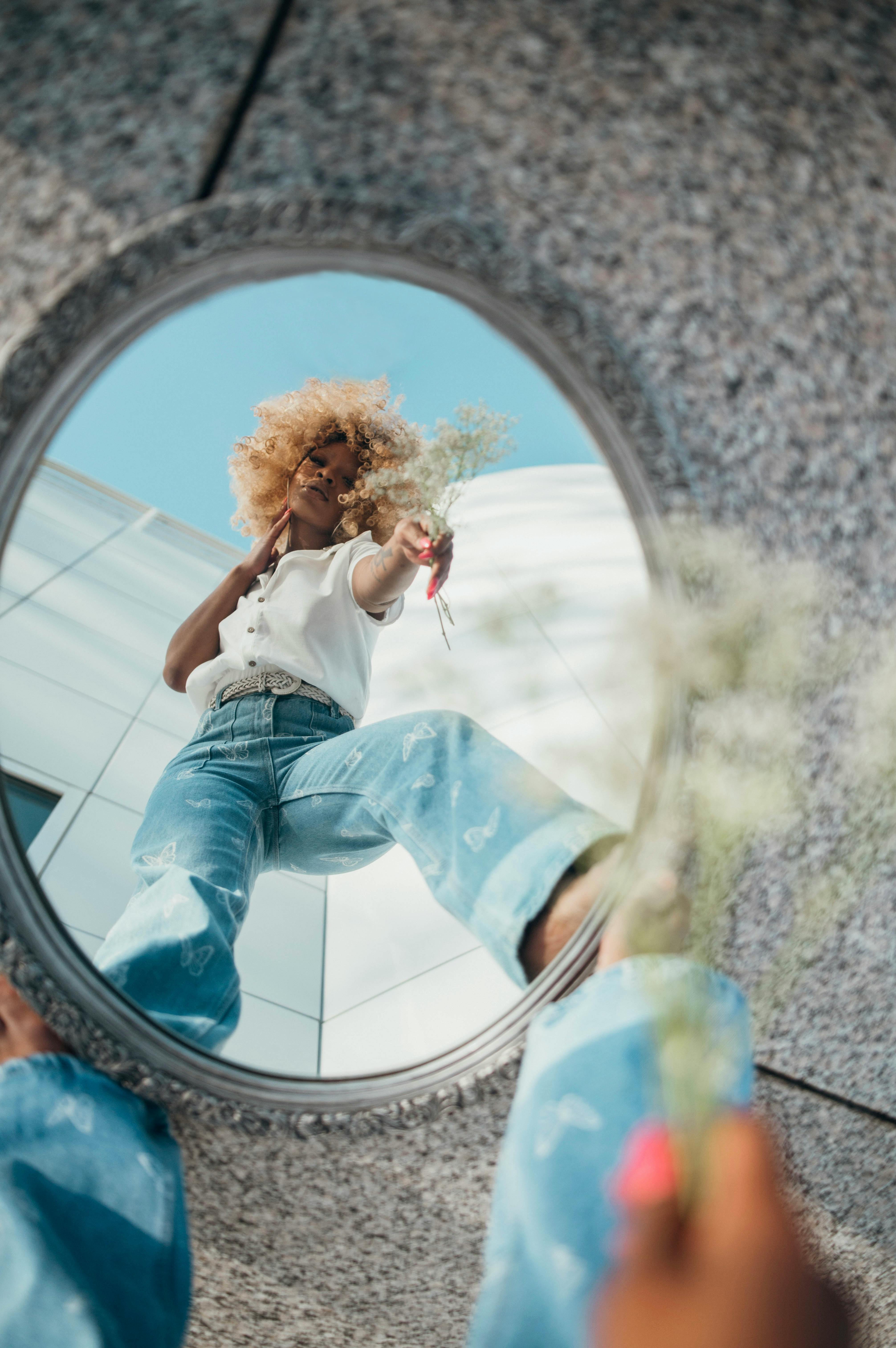 Reflection of Woman in White Dress Sitting on Brown Rock Near Body of ...