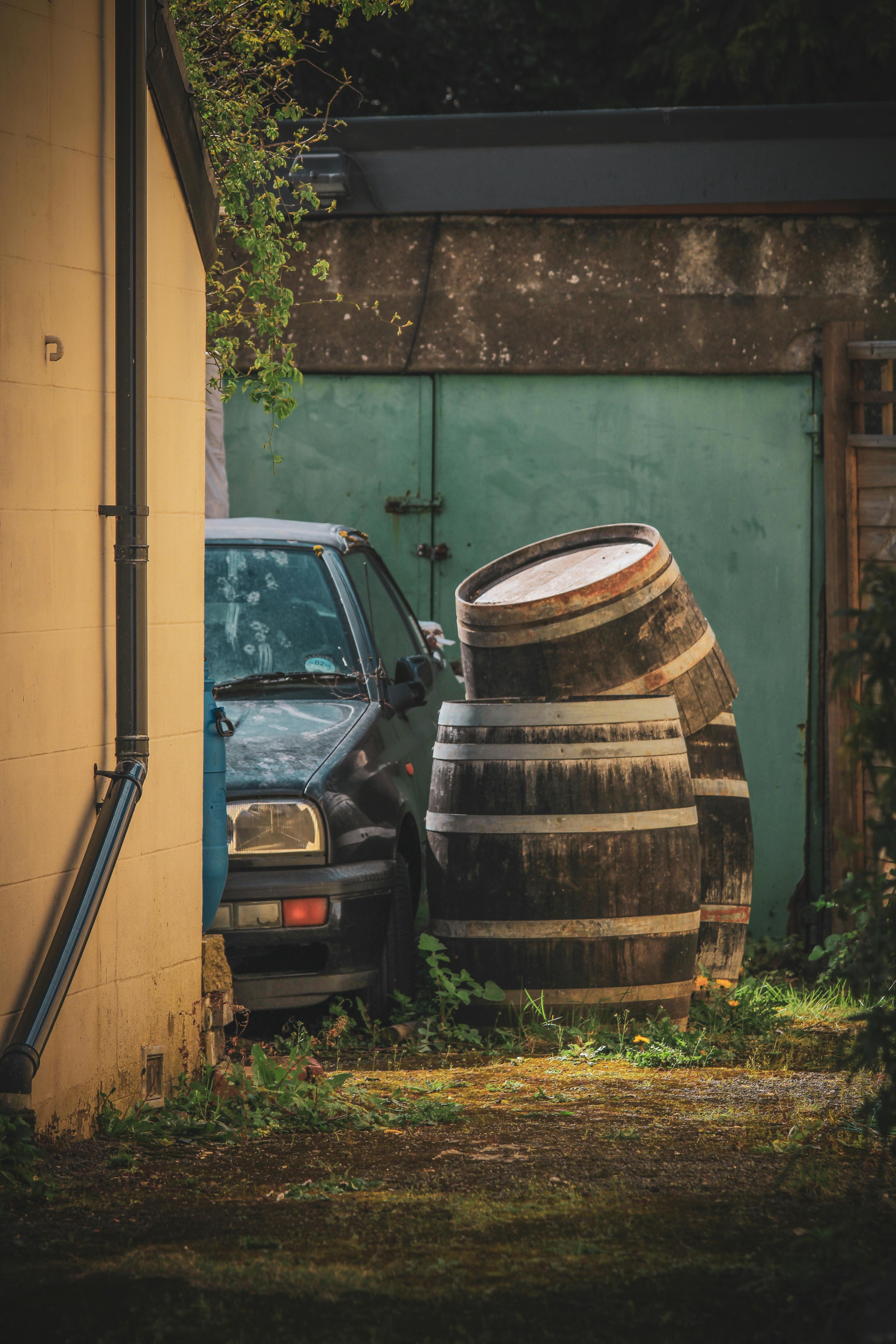 Barrels beside and Abandoned Car · Free Stock Photo