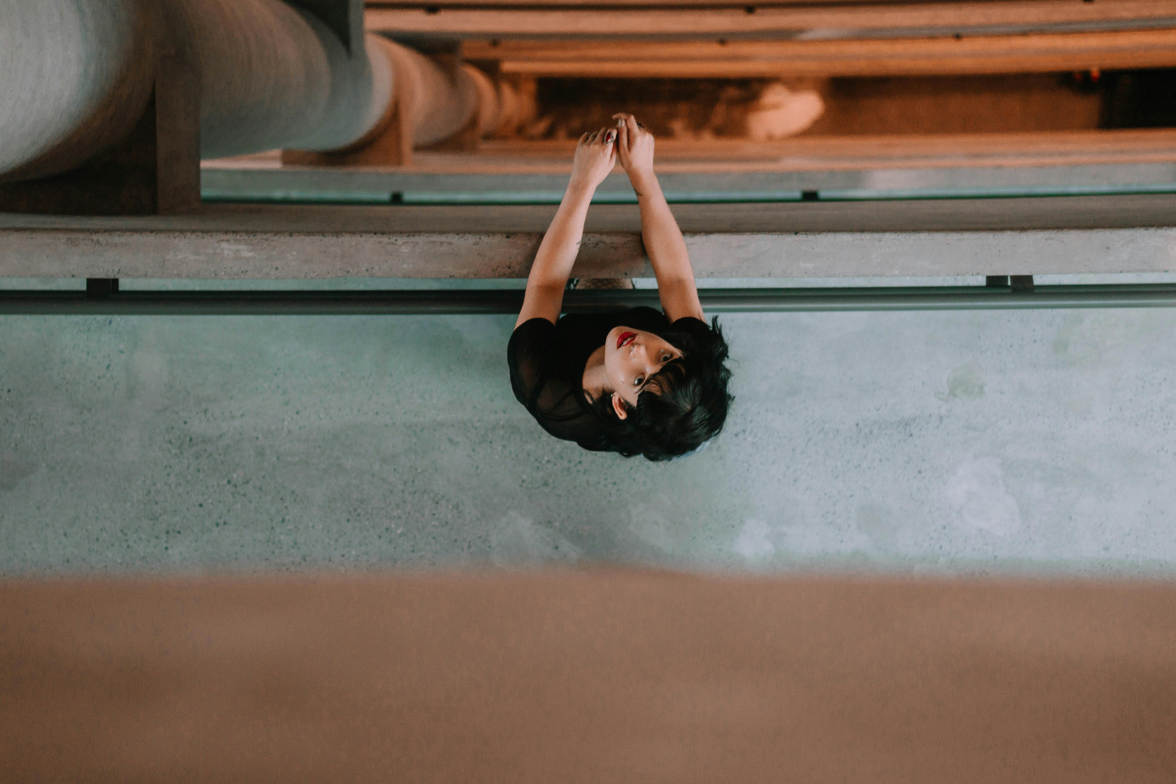 Top View of a Woman Standing and Leaning on the Railing · Free Stock Photo
