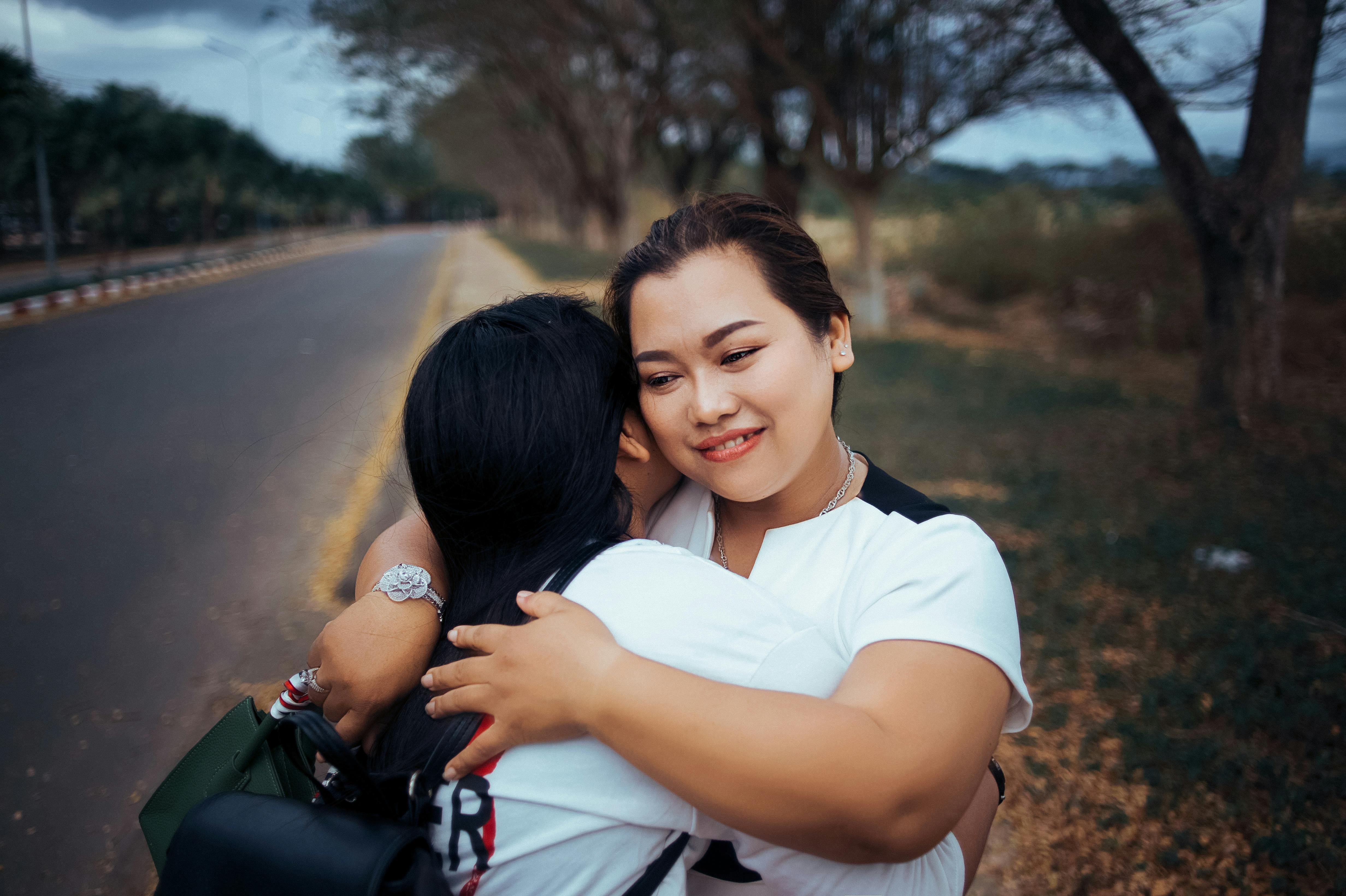 Two Women Hugging Each Other Standing on Pathway of the Road · Free ...