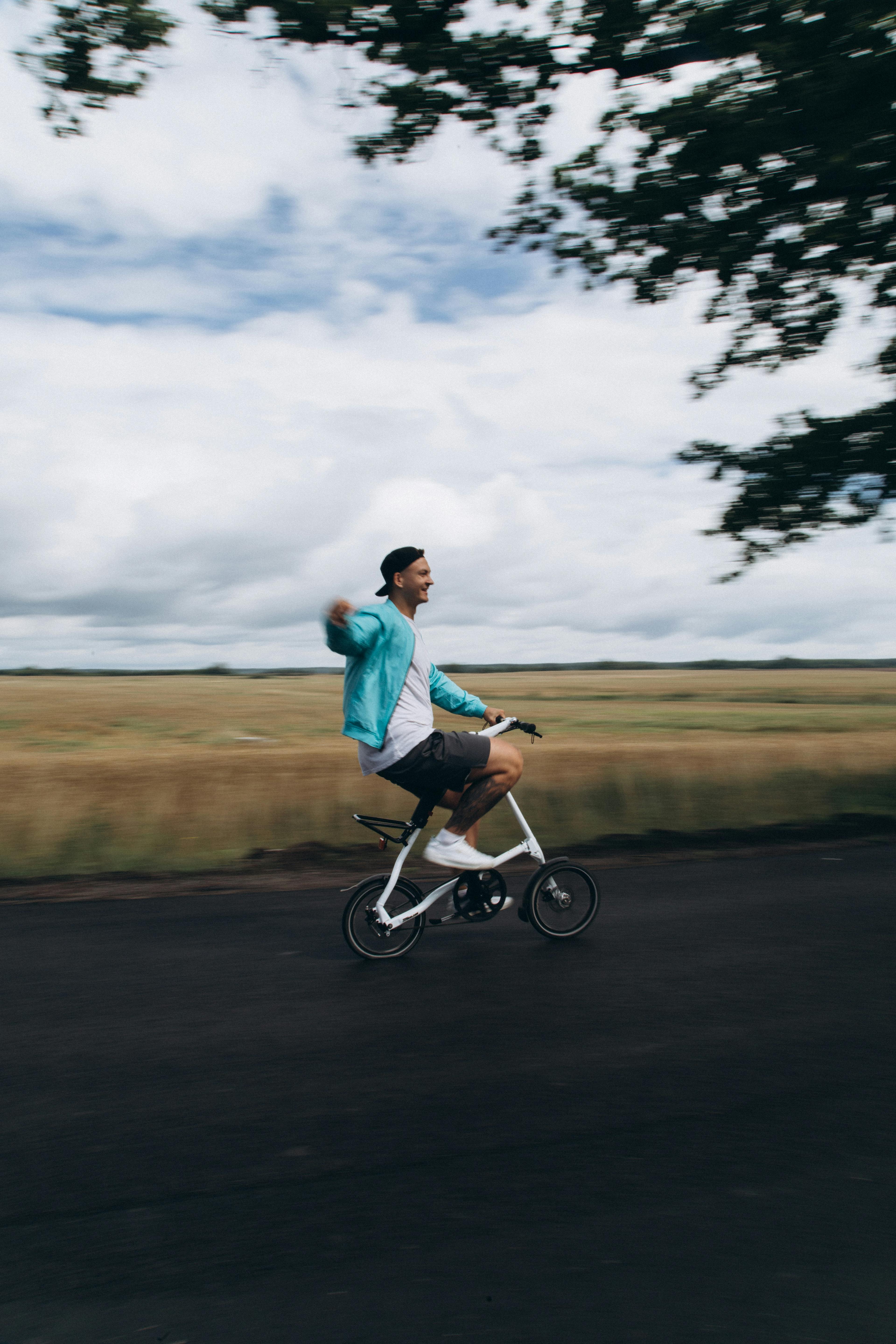A Cameraman Filming a Man Wearing Raincoat while Riding a Bike · Free ...