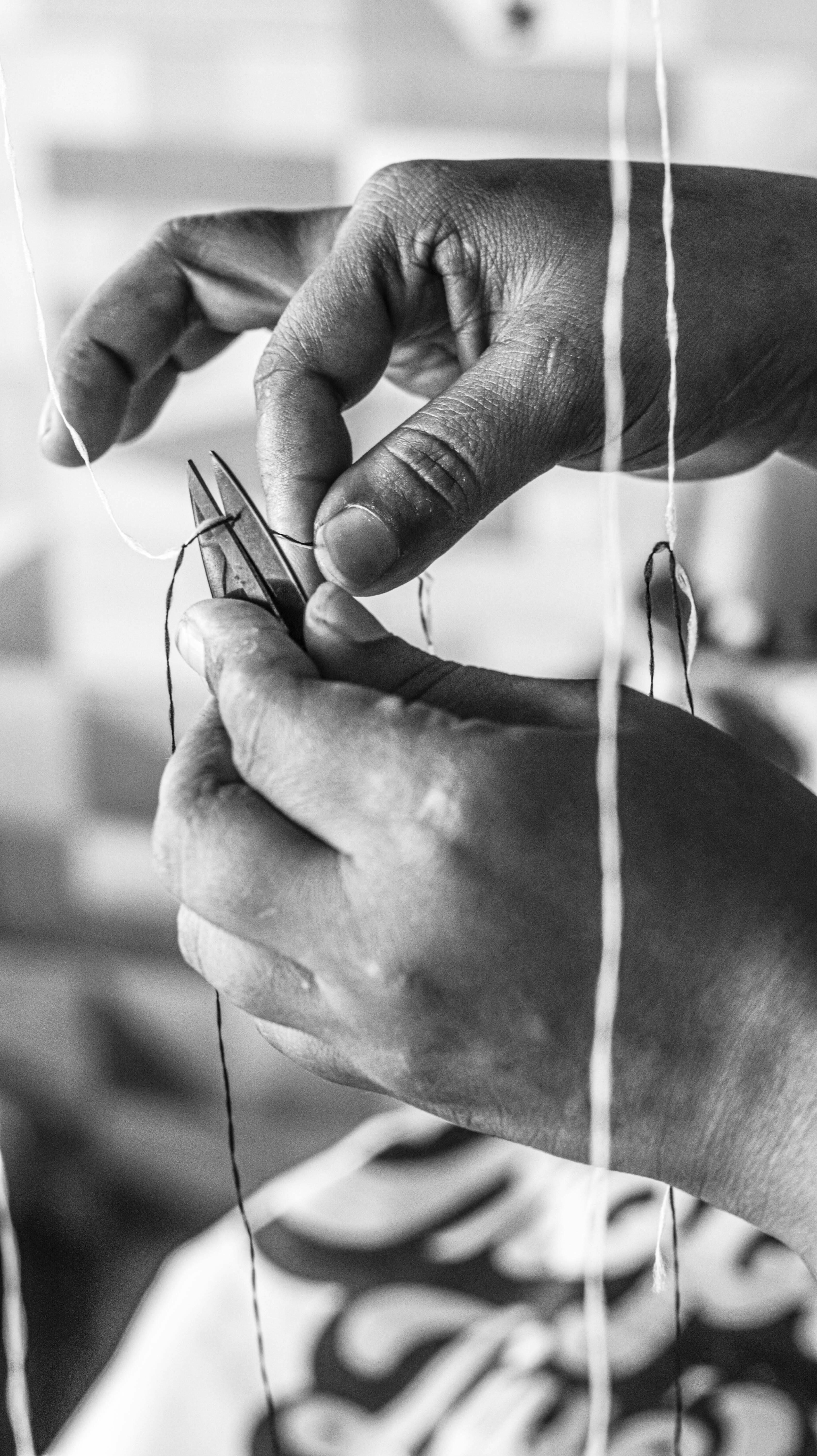 Grayscale Photo of a Person Cutting a Thread · Free Stock Photo
