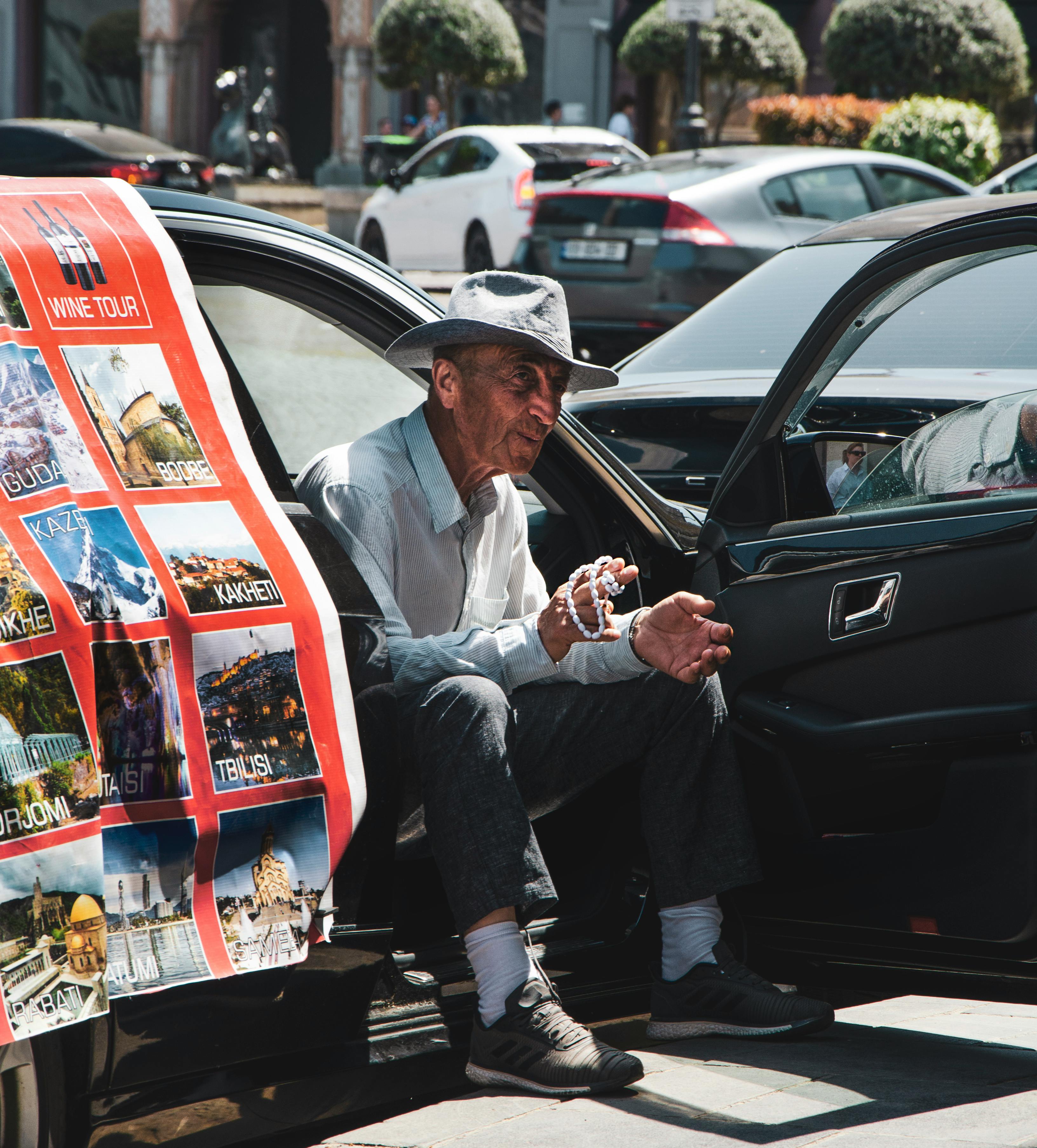 Portrait of Elderly Man with Cigar Sitting on Dusty Car · Free Stock Photo