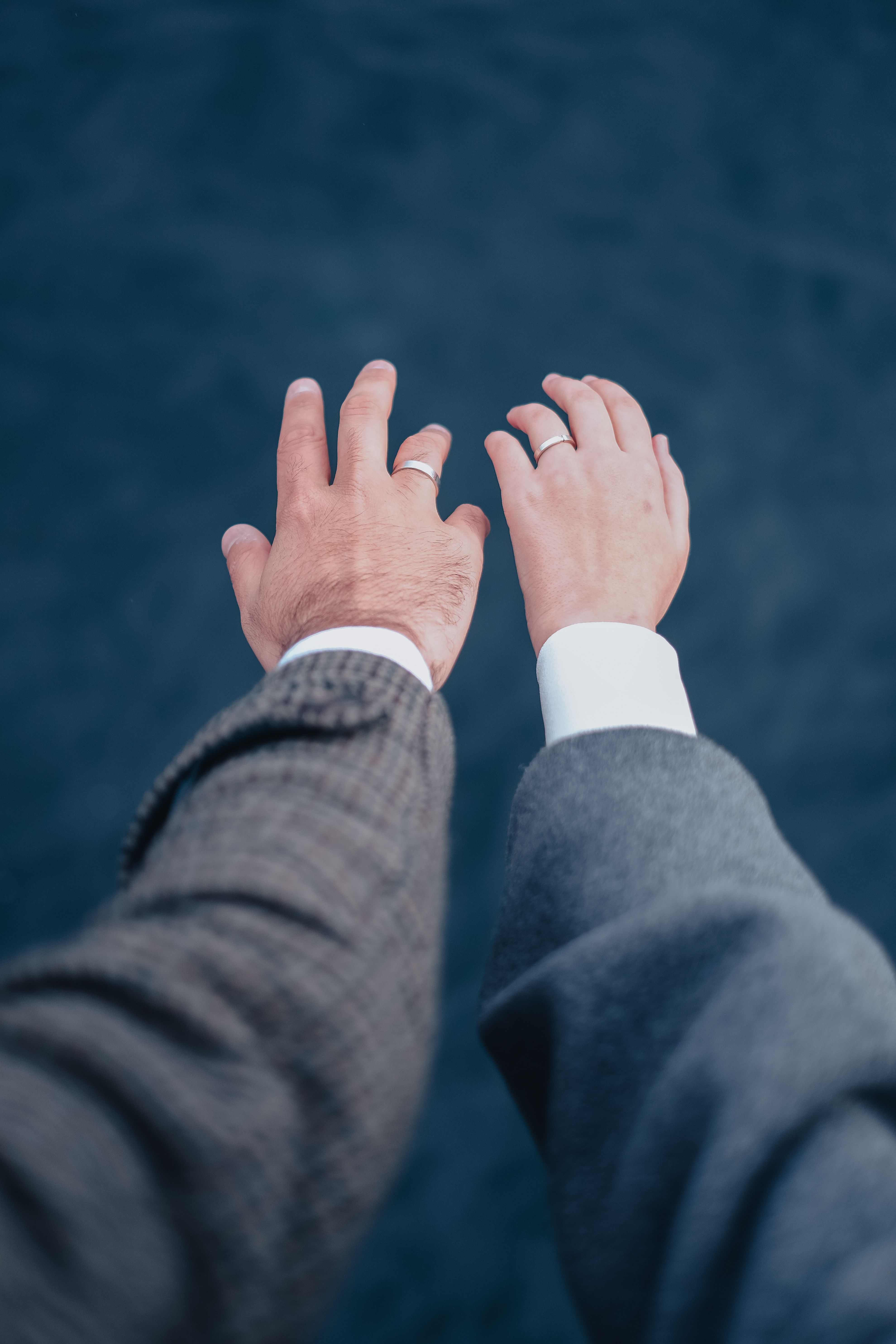 Hands Wearing Wedding Rings Reaching Out · Free Stock Photo