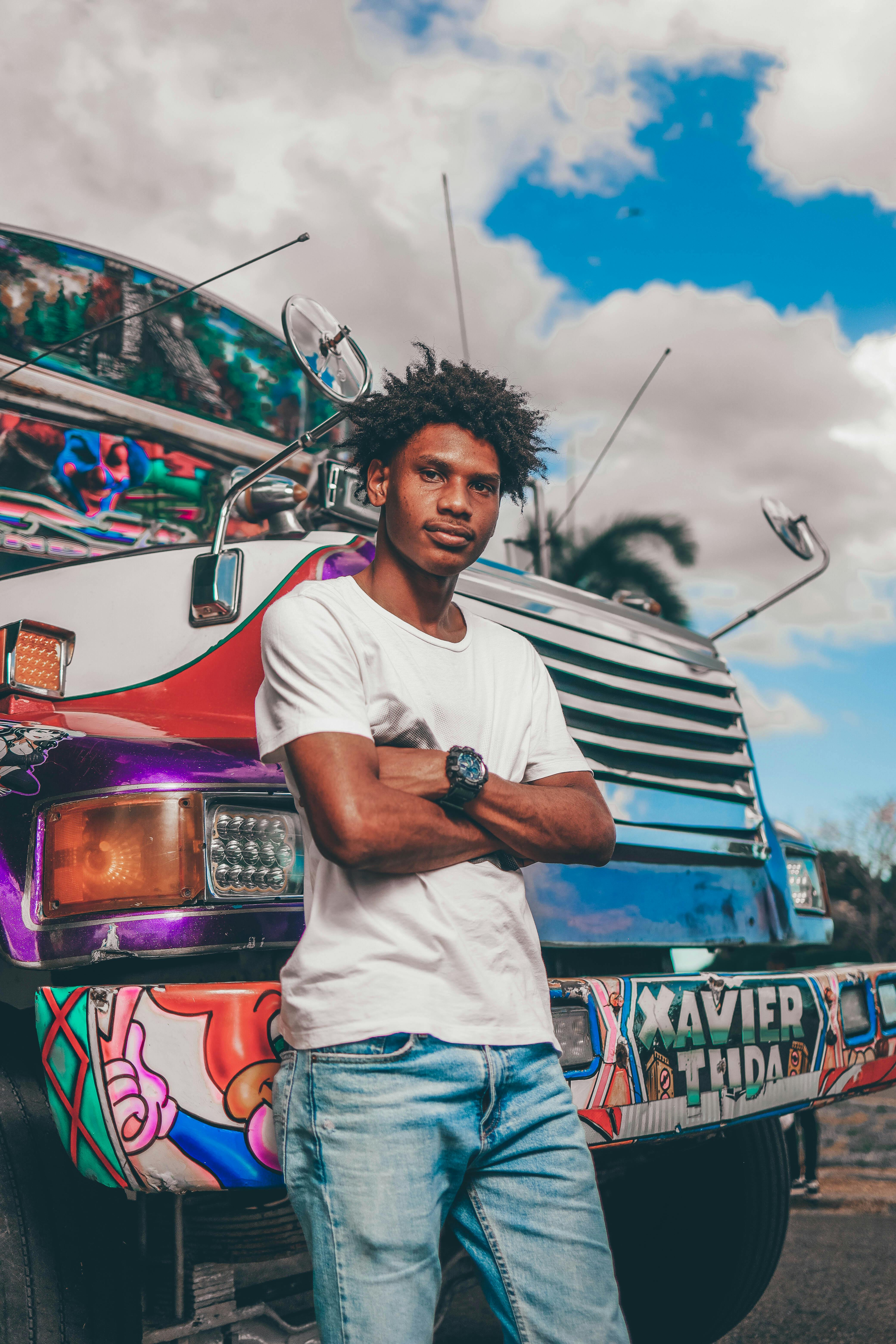 Man Standing in front of a Tuned Colourful Bus · Free Stock Photo