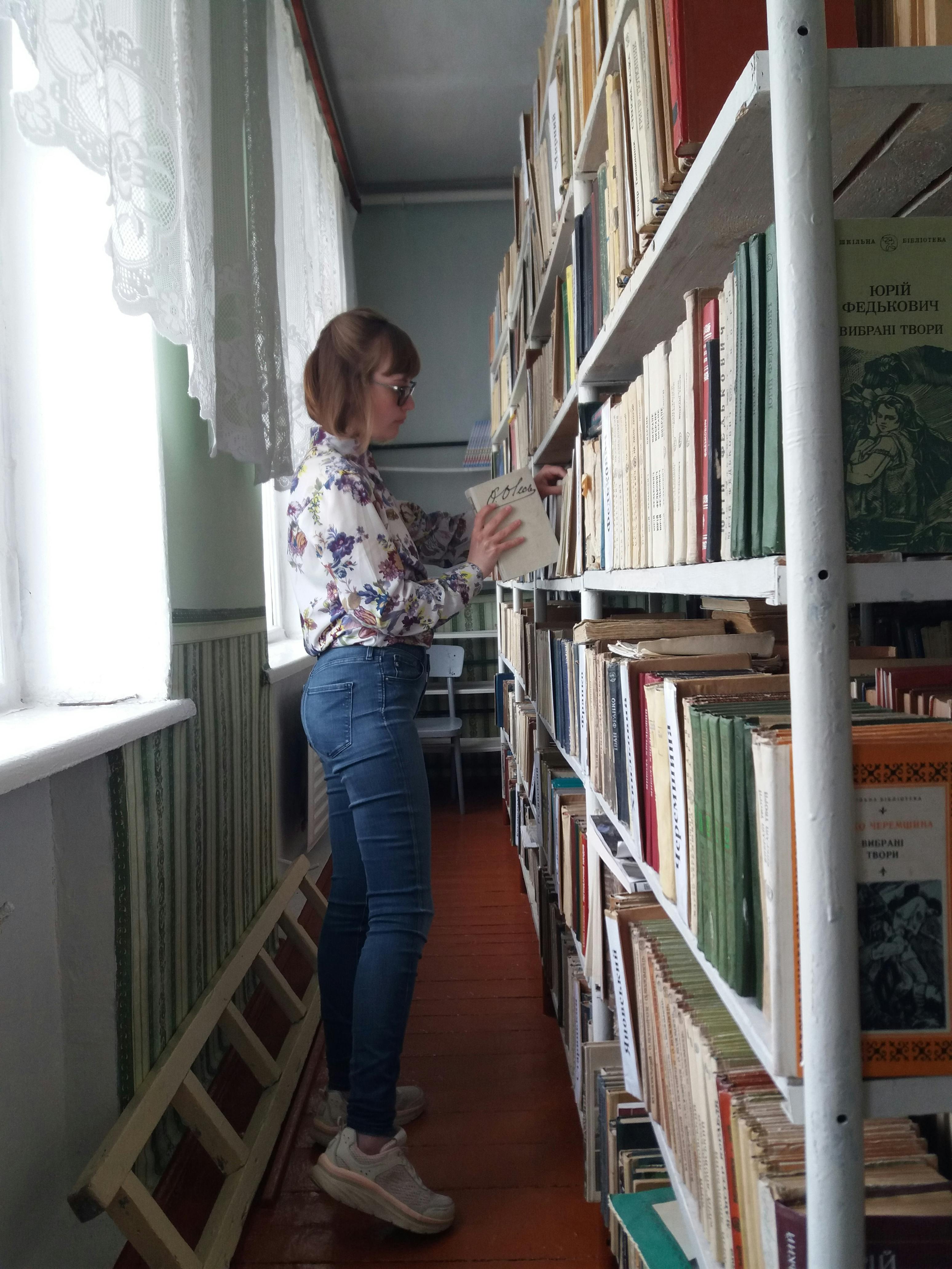 Woman getting a Book on a Book Shelf · Free Stock Photo