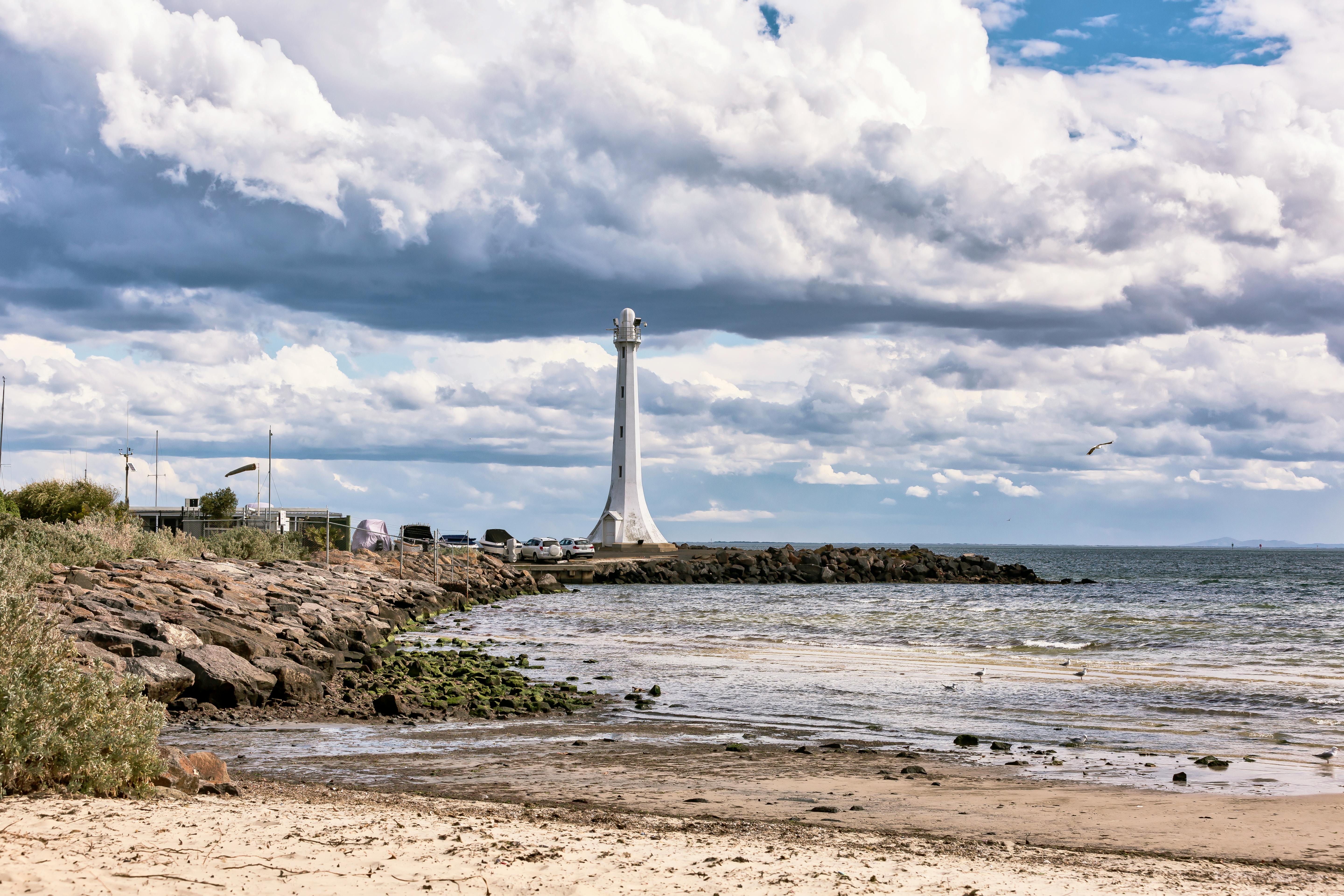 Gray Lighthouse on the Shore · Free Stock Photo