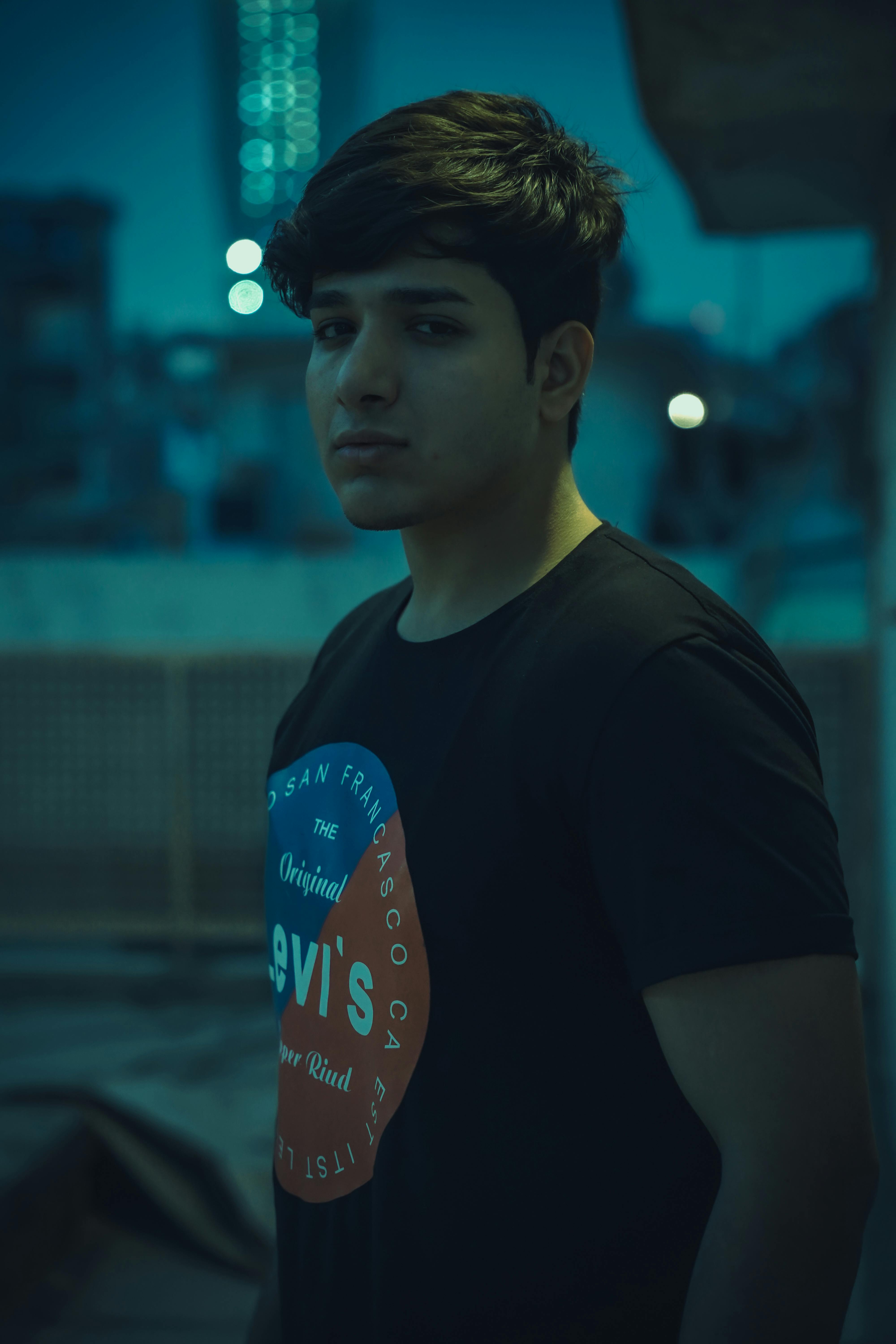 Back View of a Man Facing a Green Wall with Crosses · Free Stock Photo