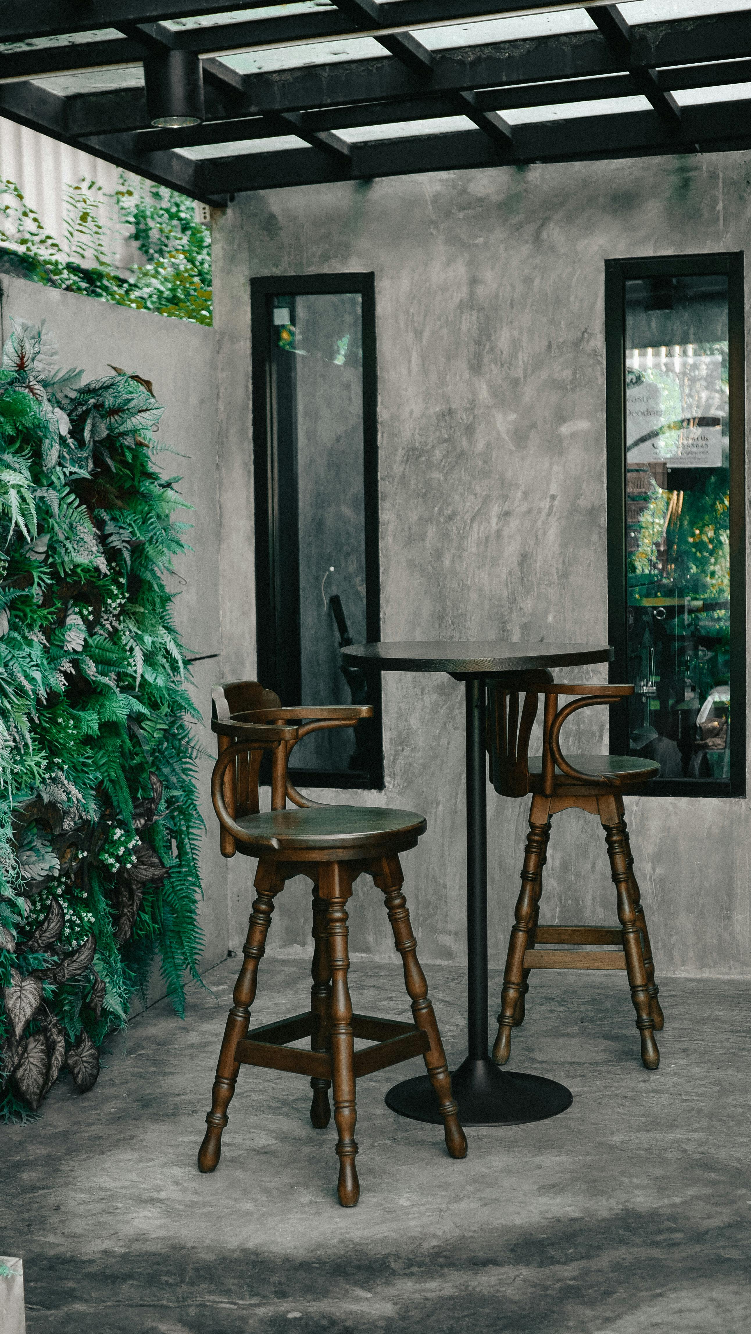 Child Outside Building Near Wooden Furniture and Tree · Free Stock Photo