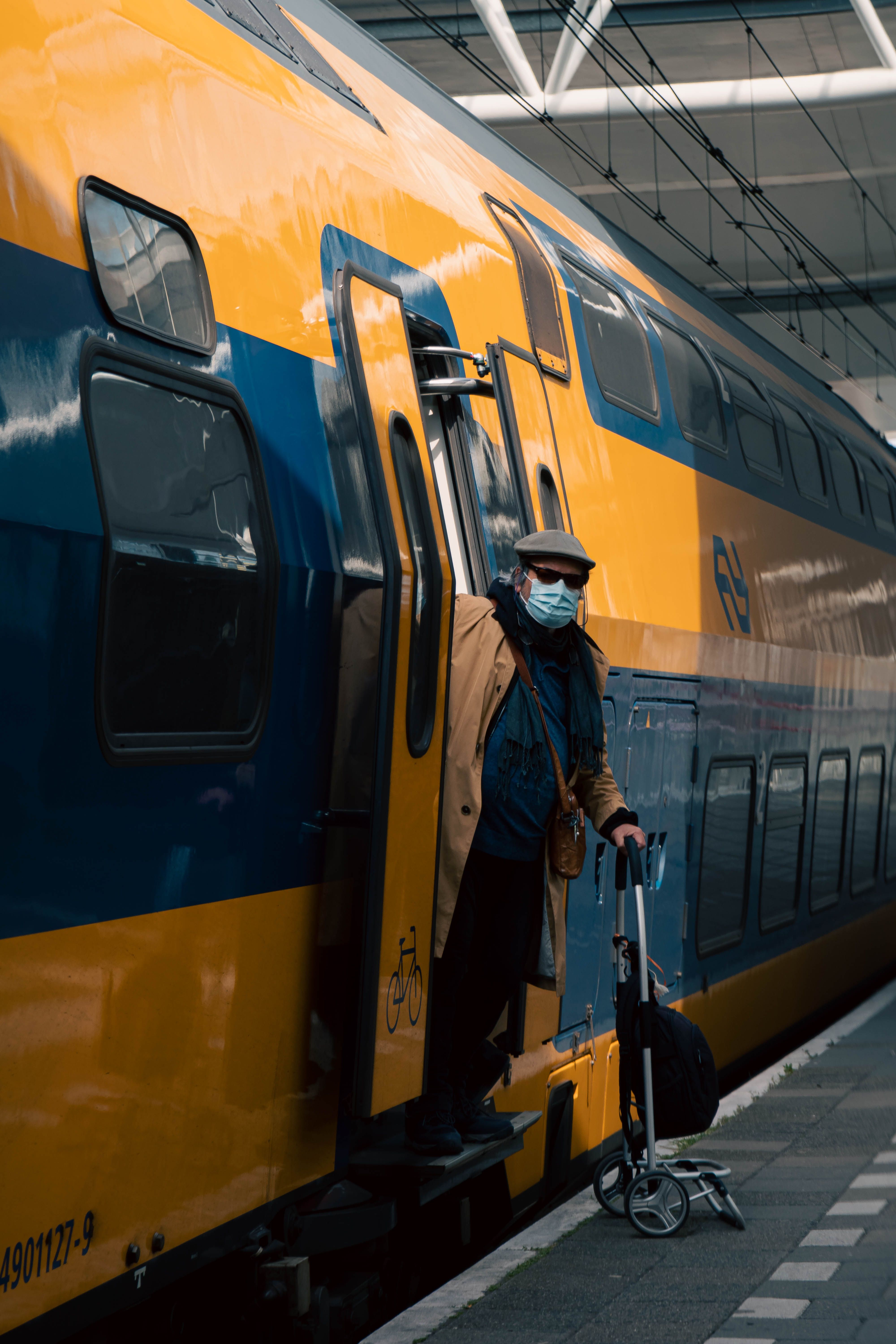 A Man Wearing Face Mask while Standing on the Train · Free Stock Photo