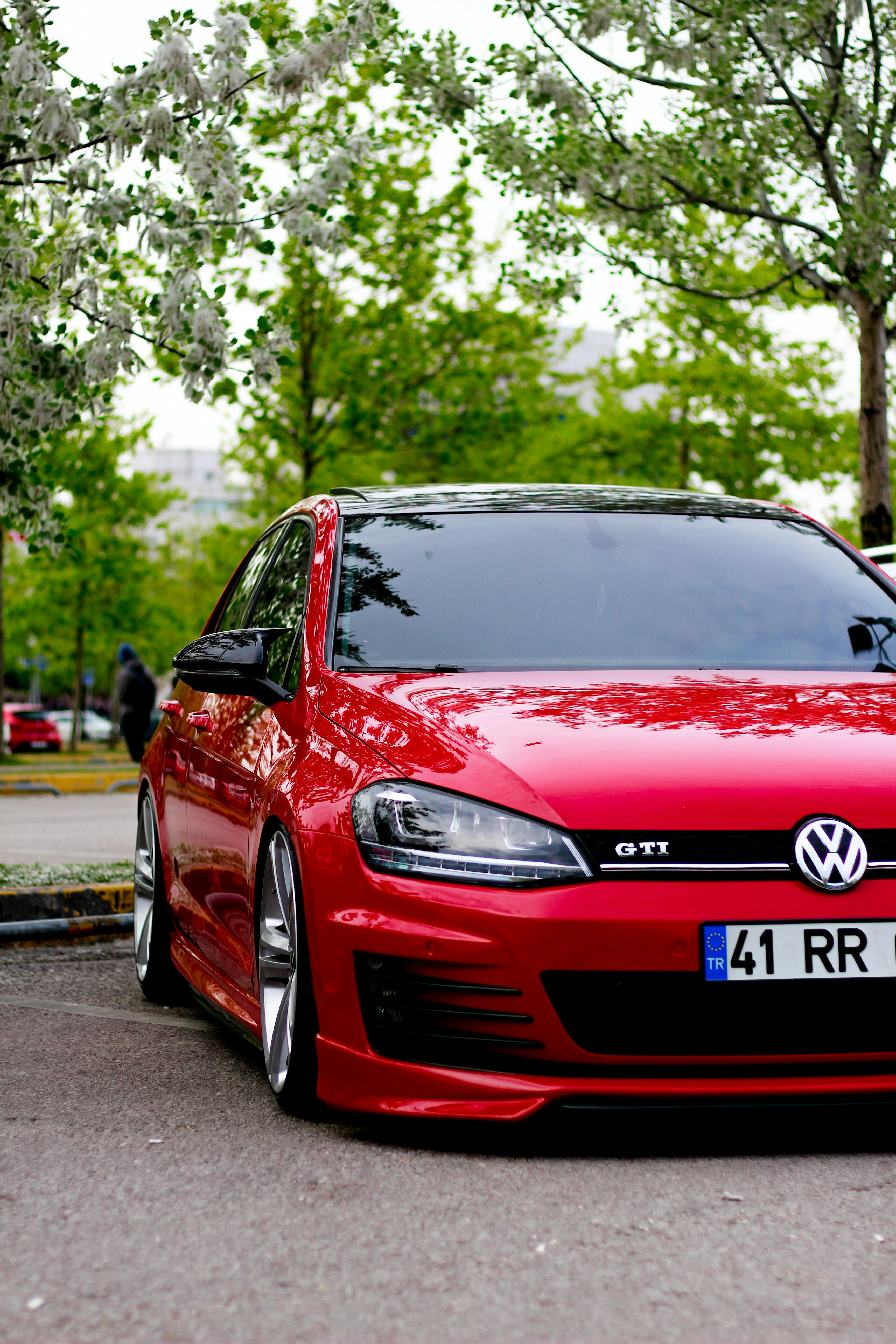A Red Volkswagen Car Parked near the Trees · Free Stock Photo