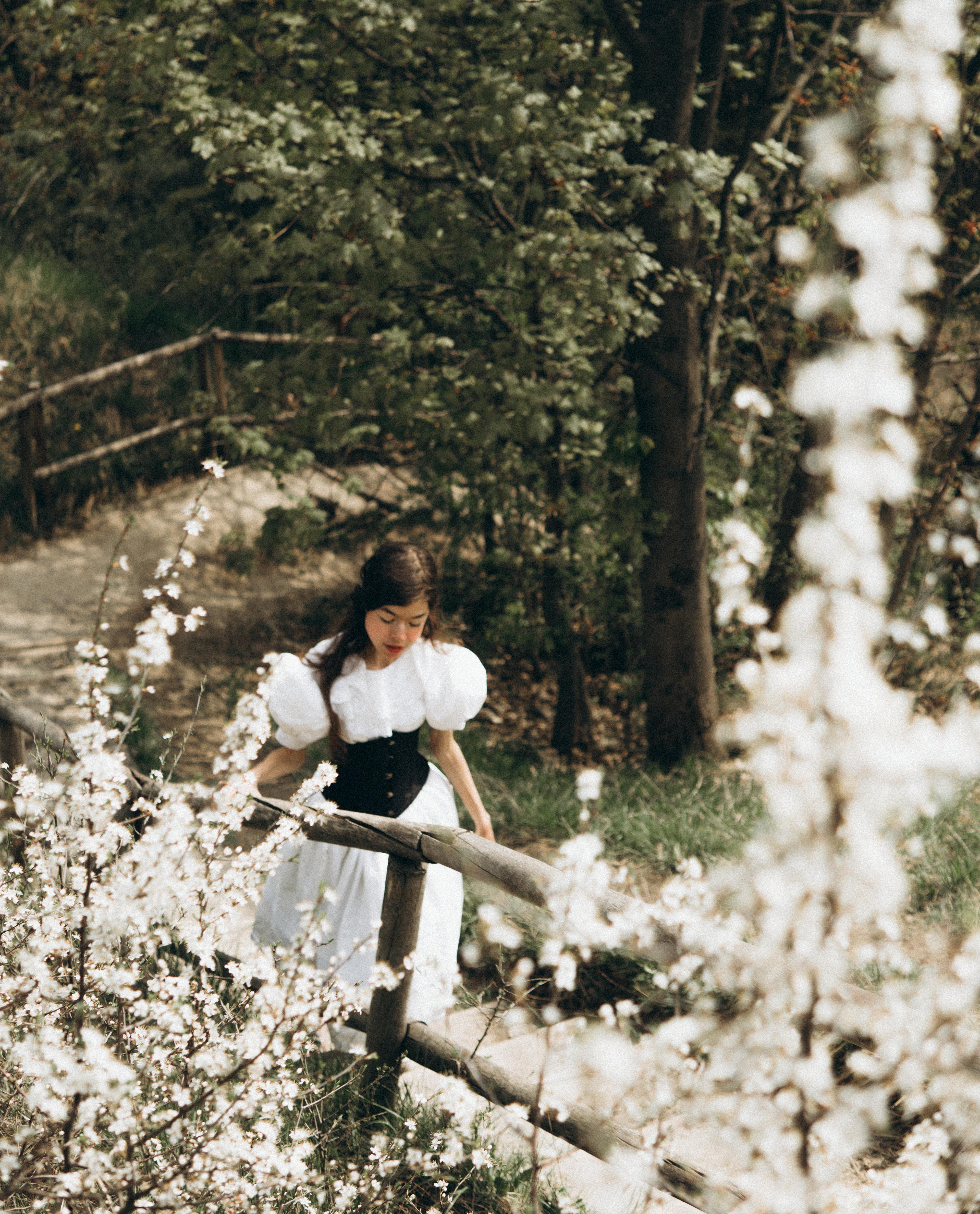 A Woman in White and Black Dress Climbing Up the Steps with Wooden ...