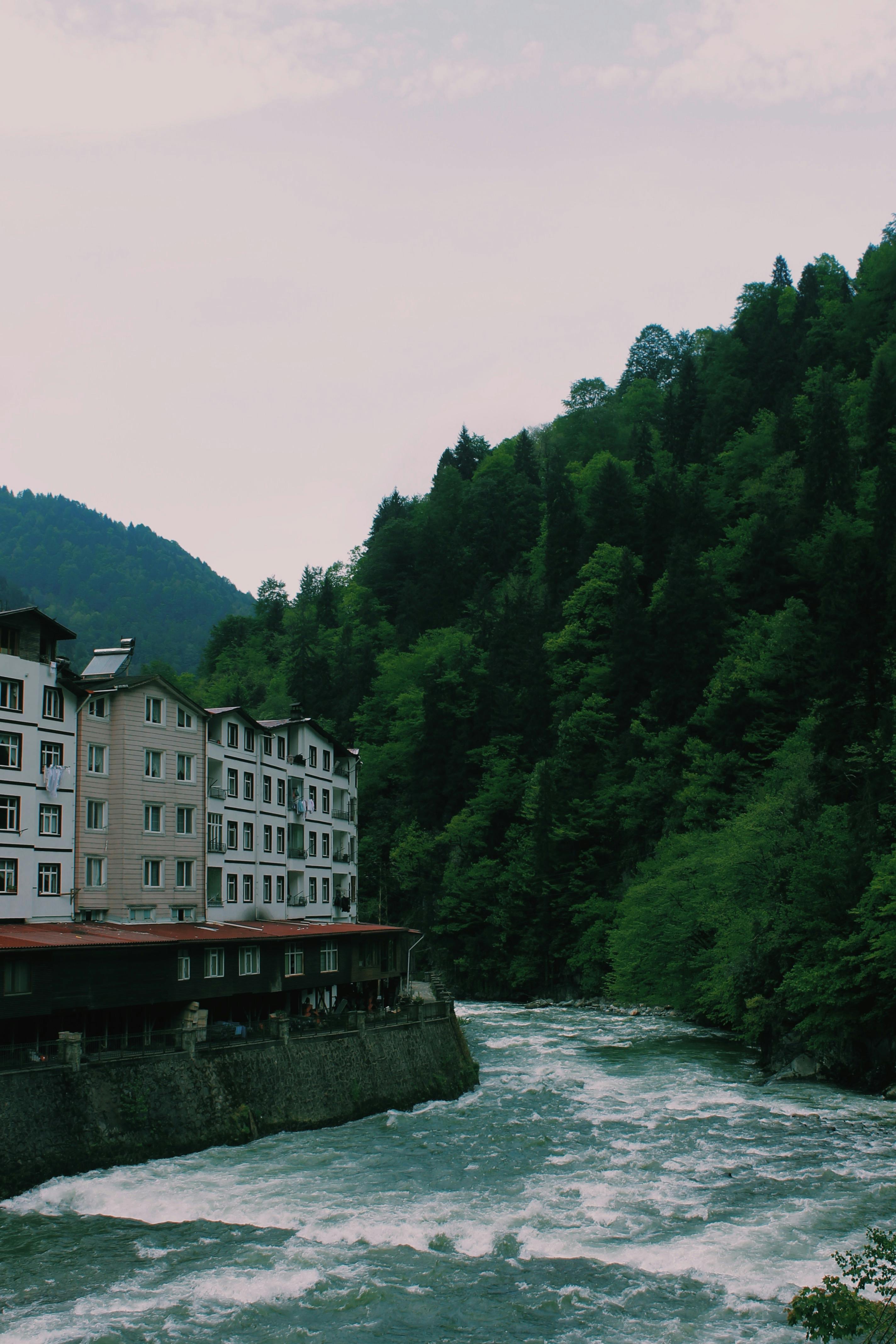 Buildings near River in Mountains · Free Stock Photo
