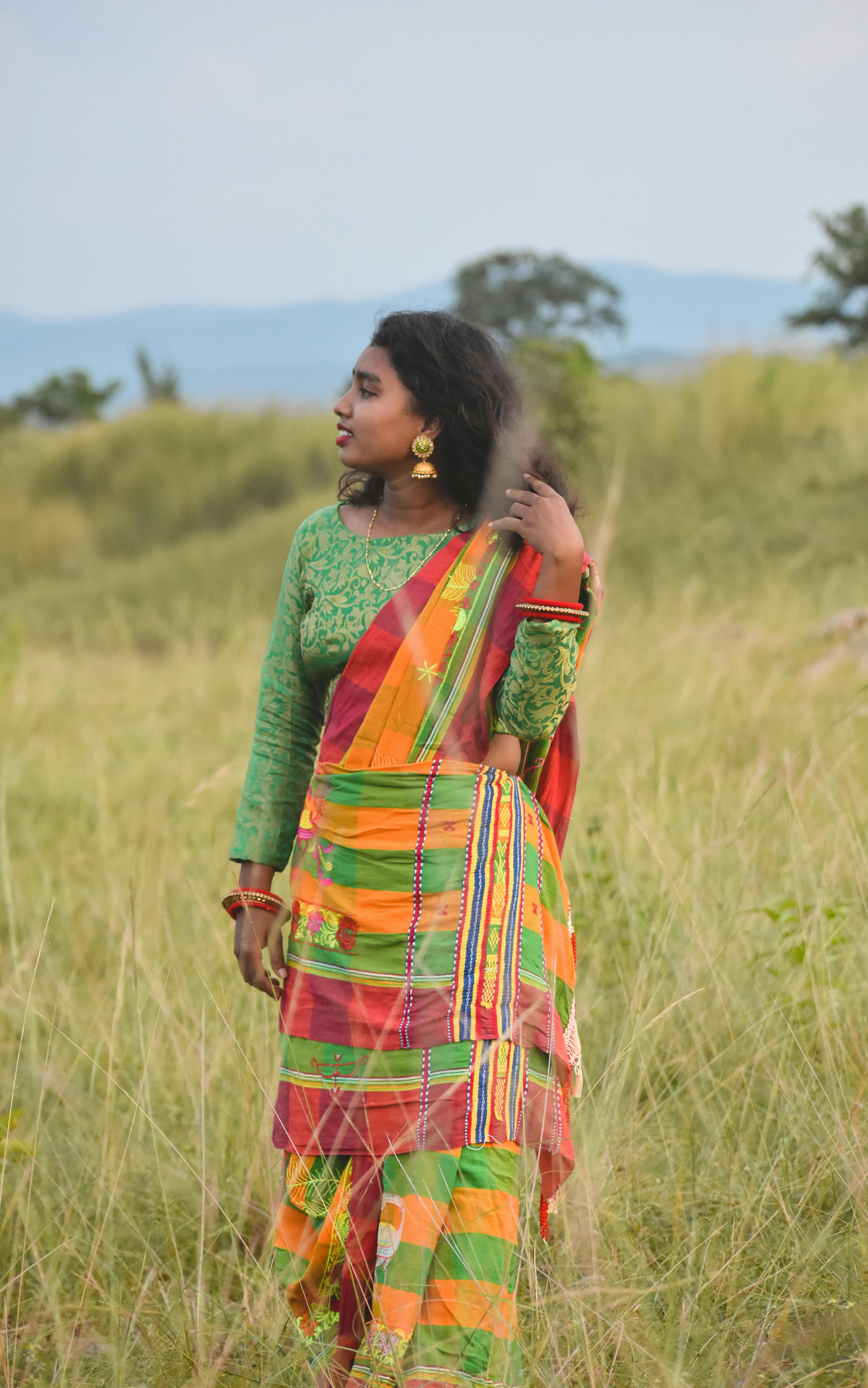 Woman in Traditional Dress Standing on Grass Field · Free Stock Photo