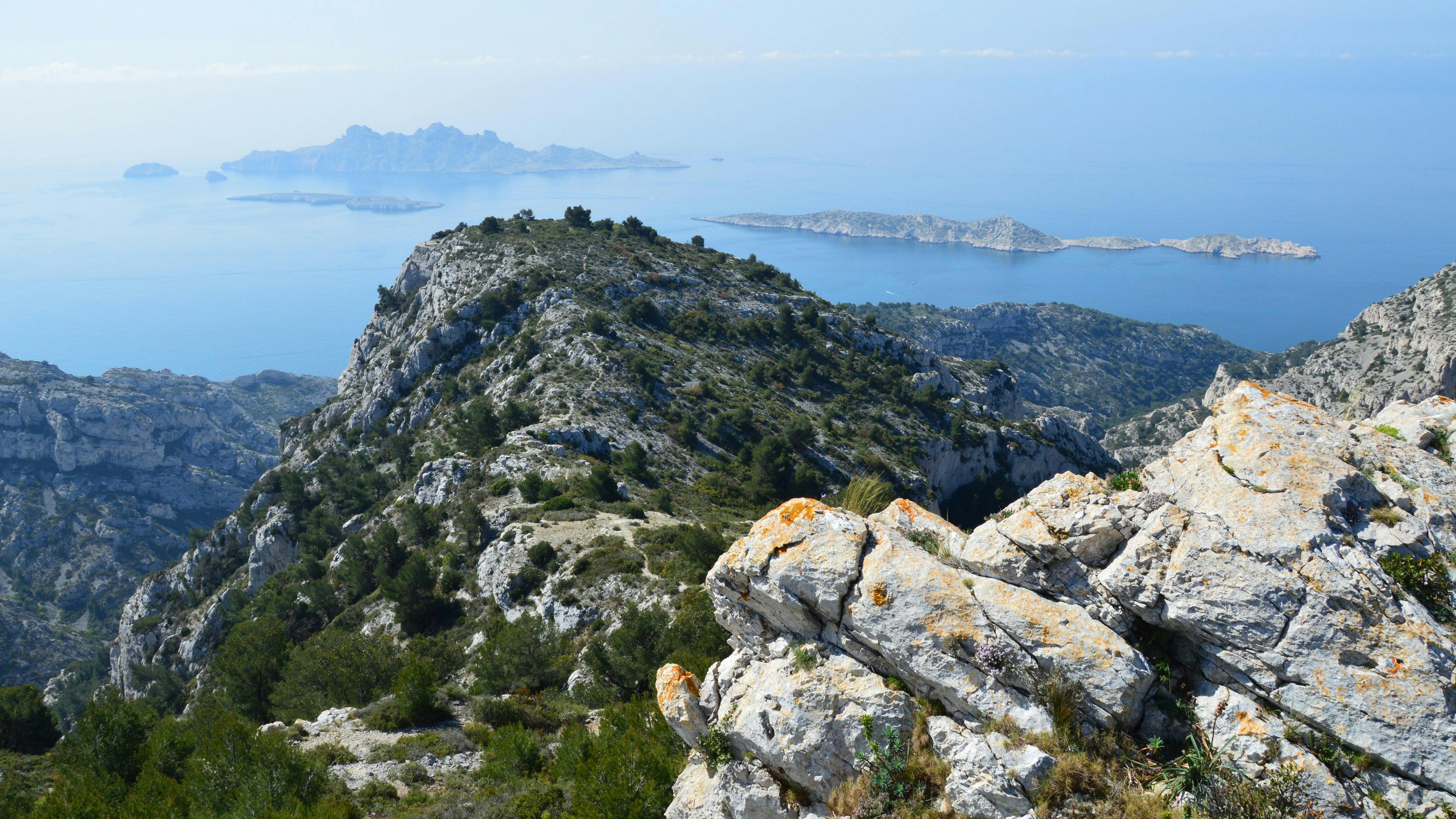 Aerial View of a Rocky Slope Above the Turquoise Sea · Free Stock Photo