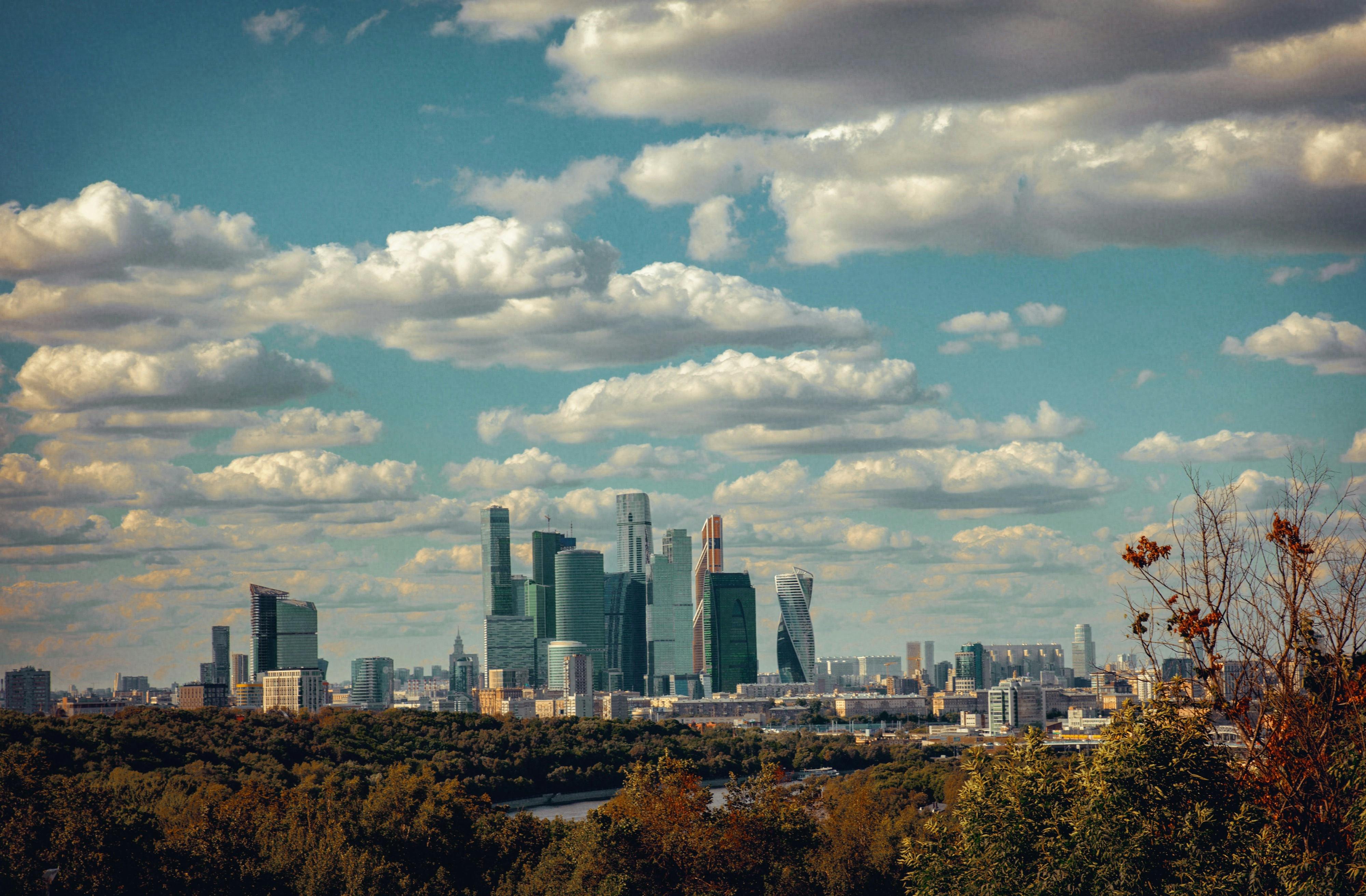 Free stock photo of clouds, green, high rise buildings