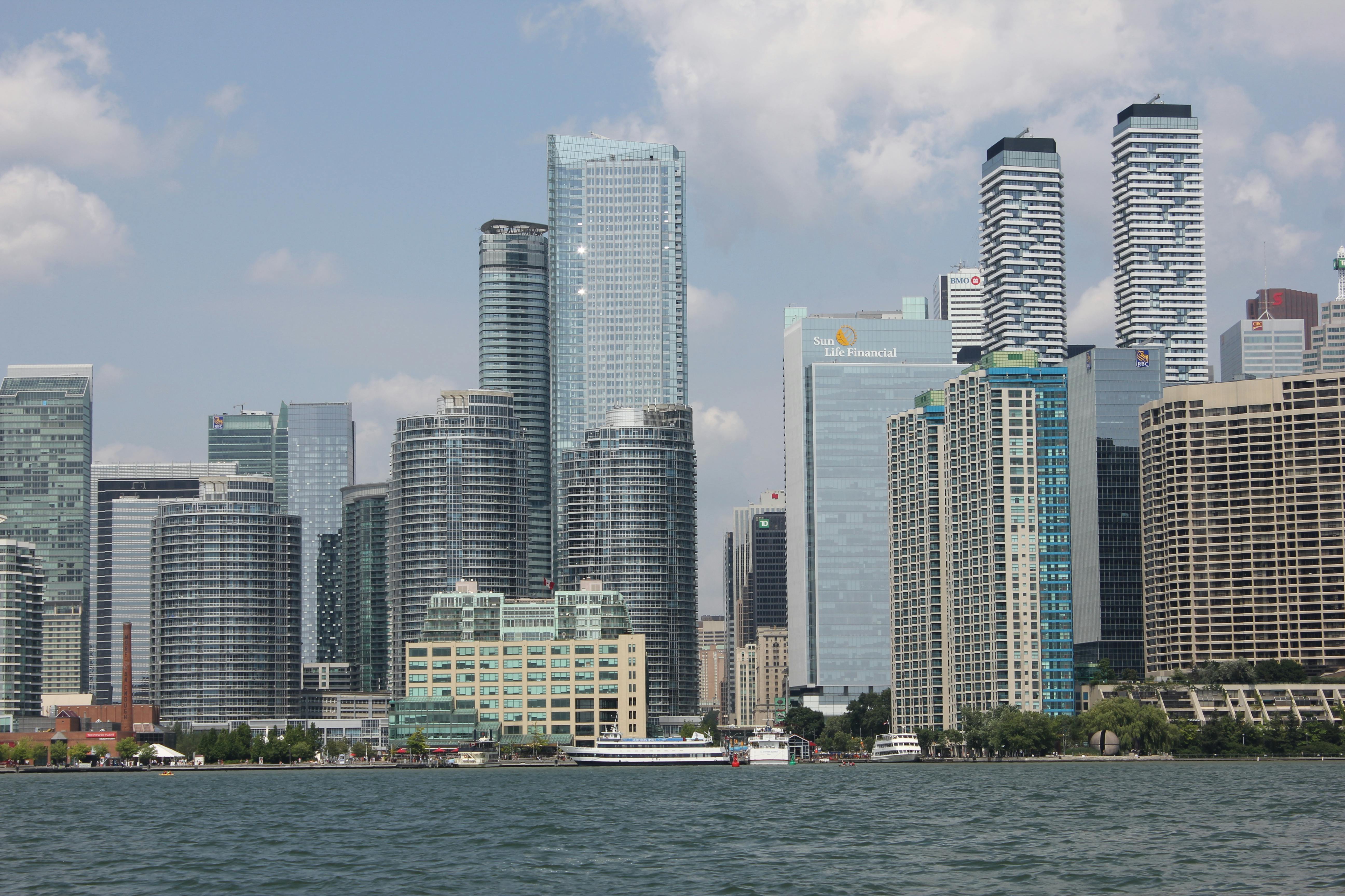 High Rise Buildings beside Body of Water under Blue Sky · Free Stock Photo