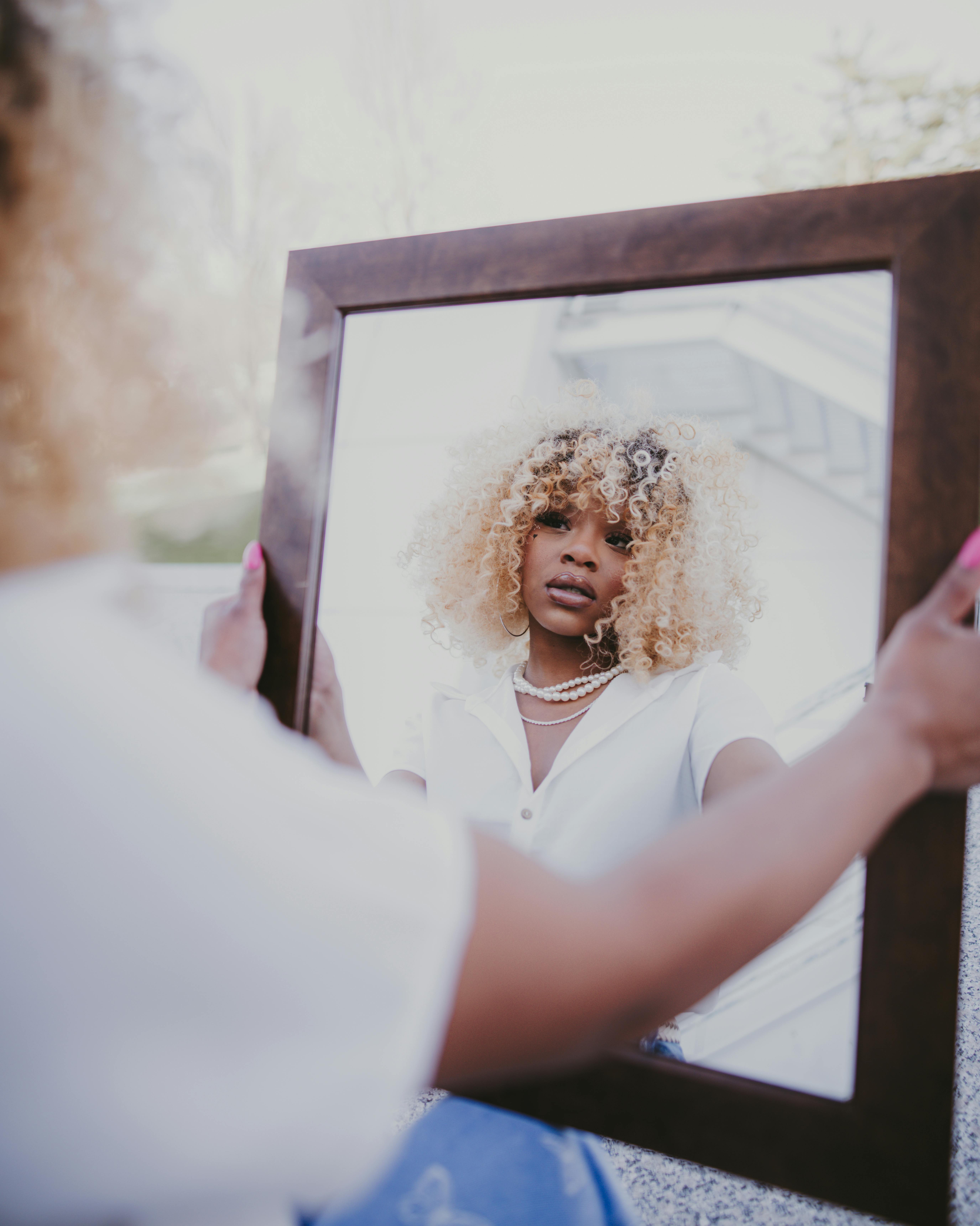 A Woman Looking at Her Reflection in the Mirror · Free Stock Photo