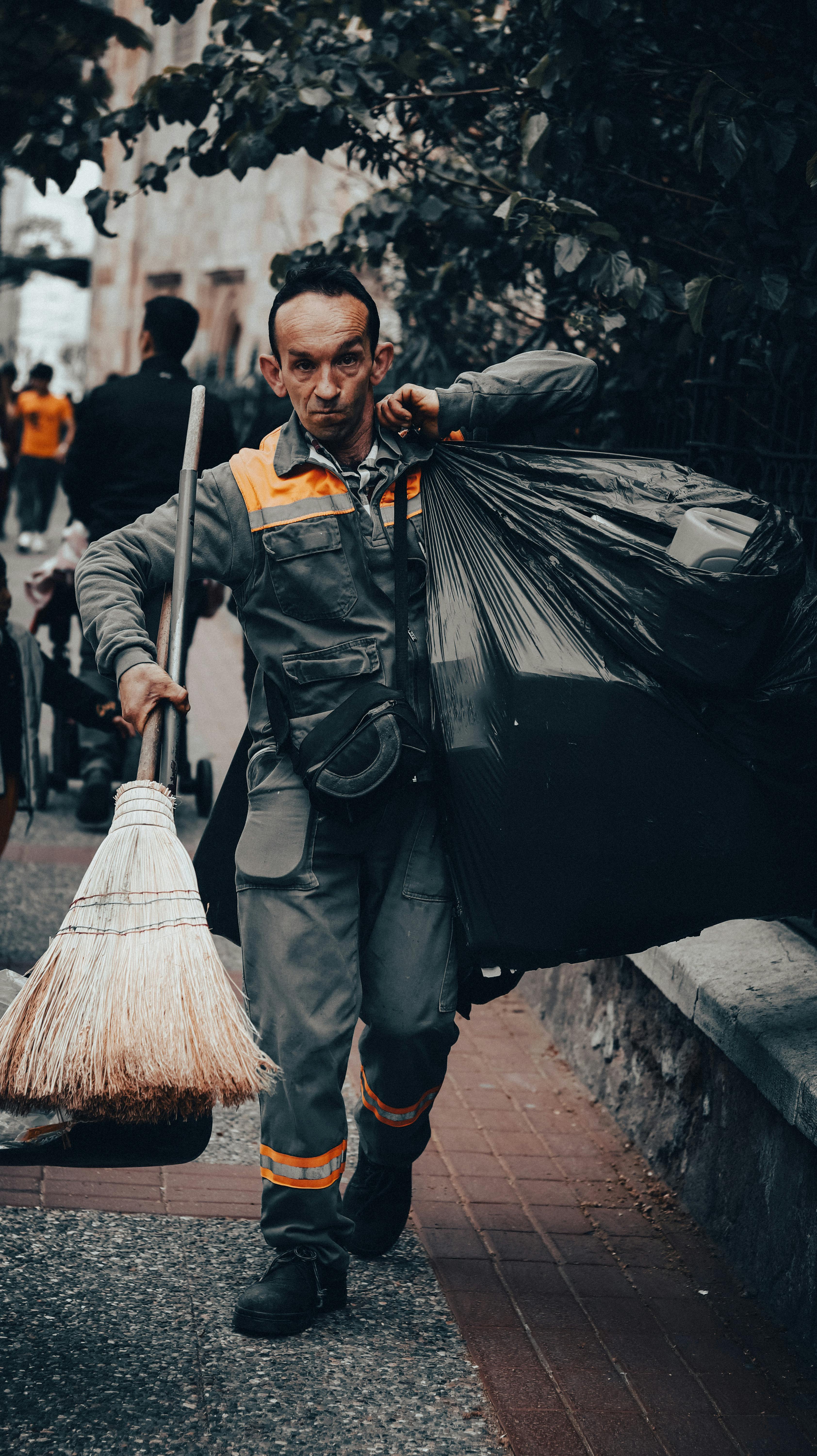 A Cleaner Carrying Plastic Garbage and Cleaning Materials while Walking ...