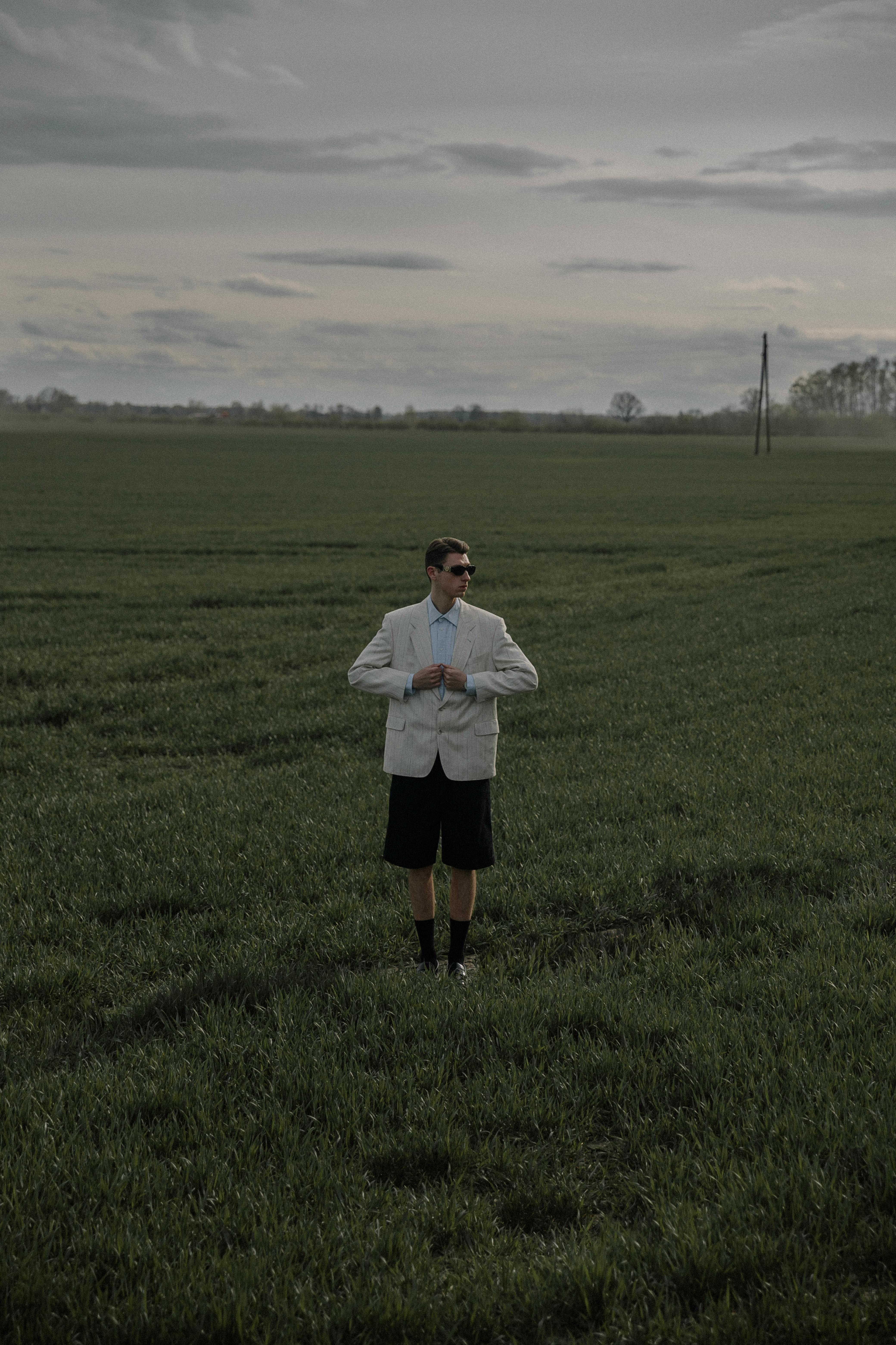 Stylish Man Standing on Grass · Free Stock Photo