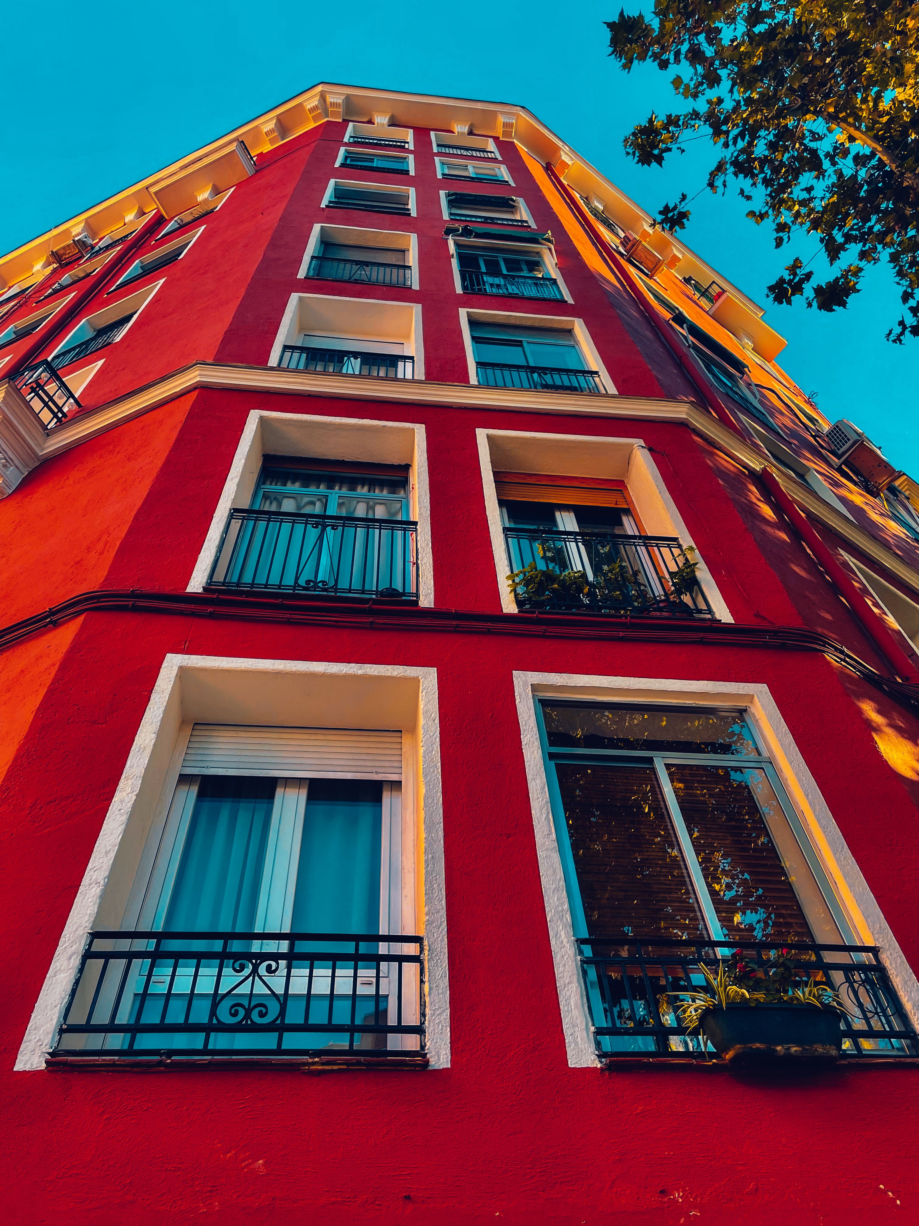Low Angle Shot of Red Apartment Building Under Blue Sky · Free Stock Photo