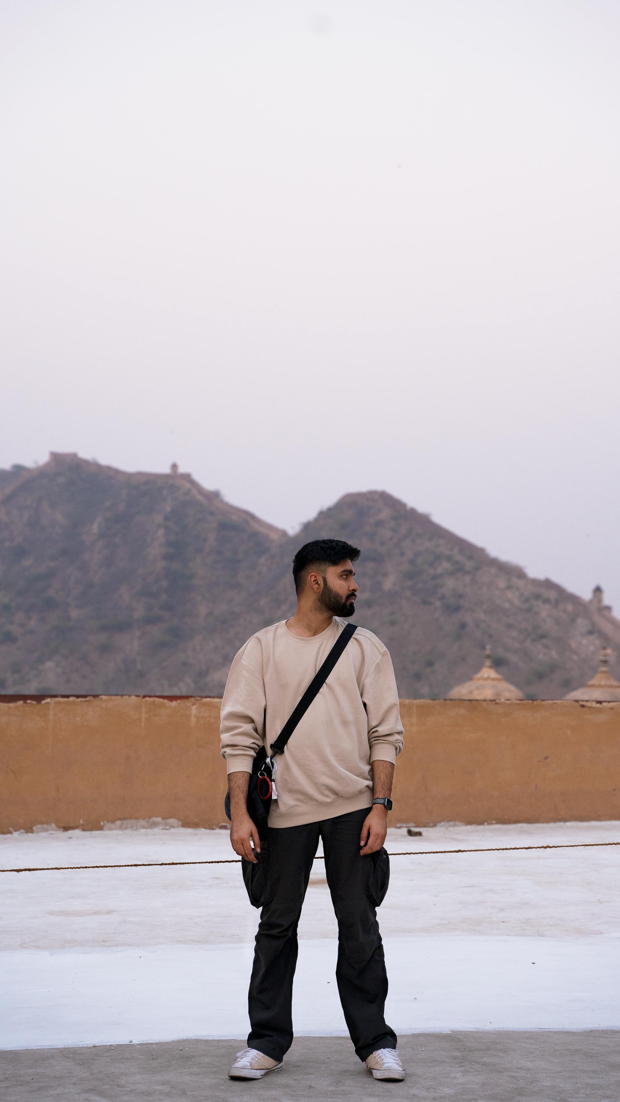 Man in Beige Sweatshirt and Black Pants Standing while Looking Afar ...