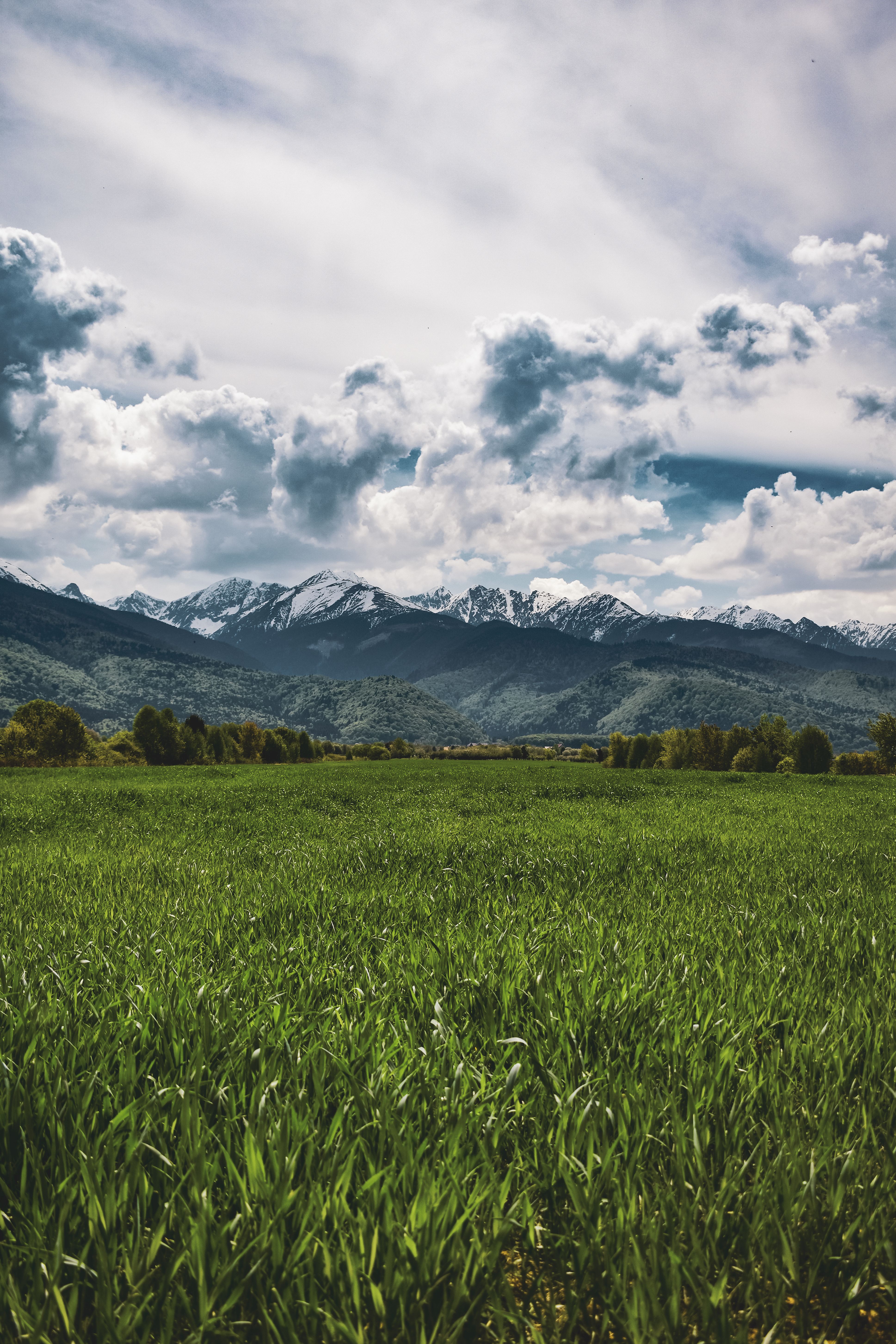 Green Grass Field Near Mountain Under White Clouds · Free Stock Photo