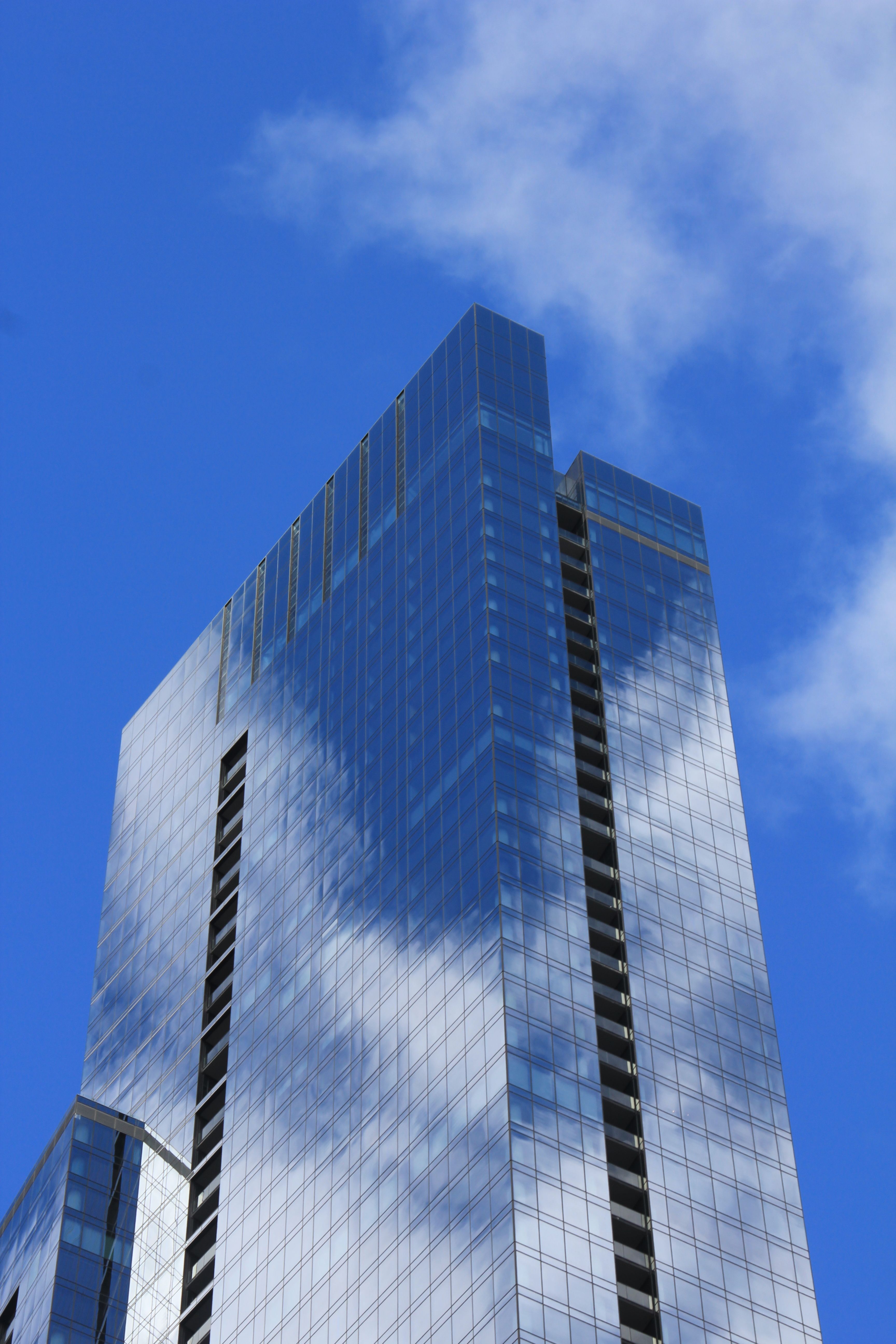 Blue Sky and Clouds over a Skyscraper · Free Stock Photo