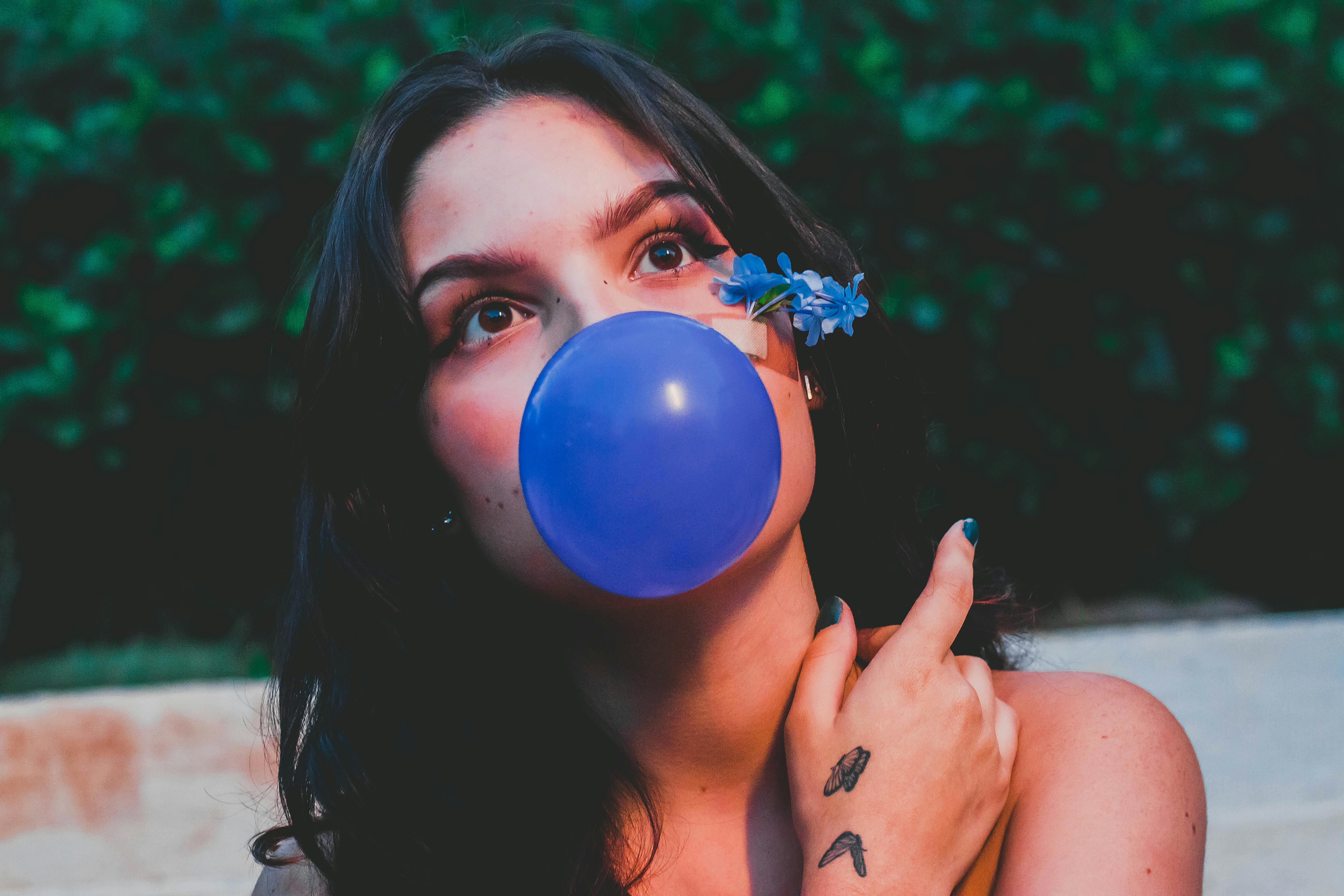 Woman Blowing Blue Balloon · Free Stock Photo