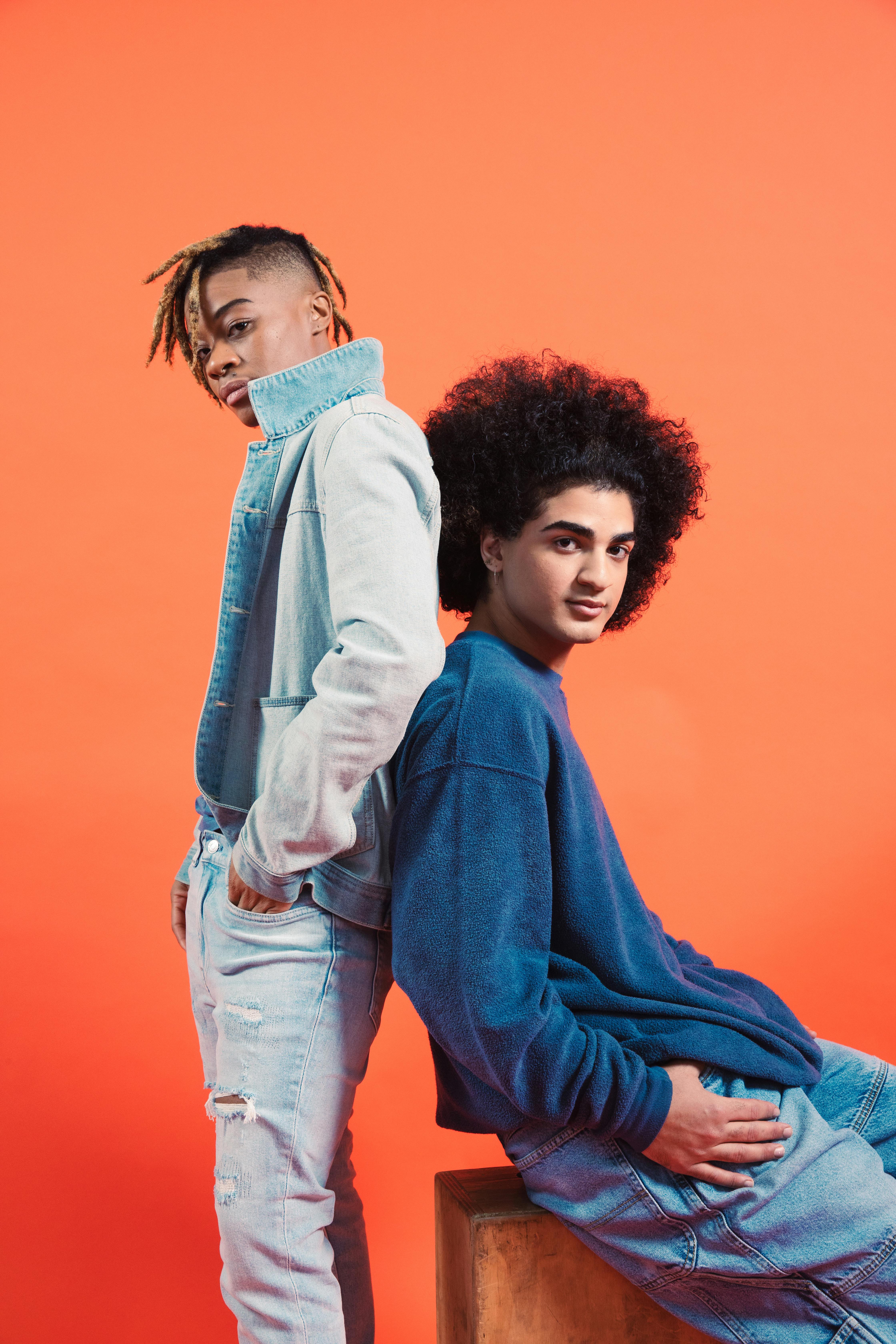 Men Posing Back to Back in Orange Background · Free Stock Photo