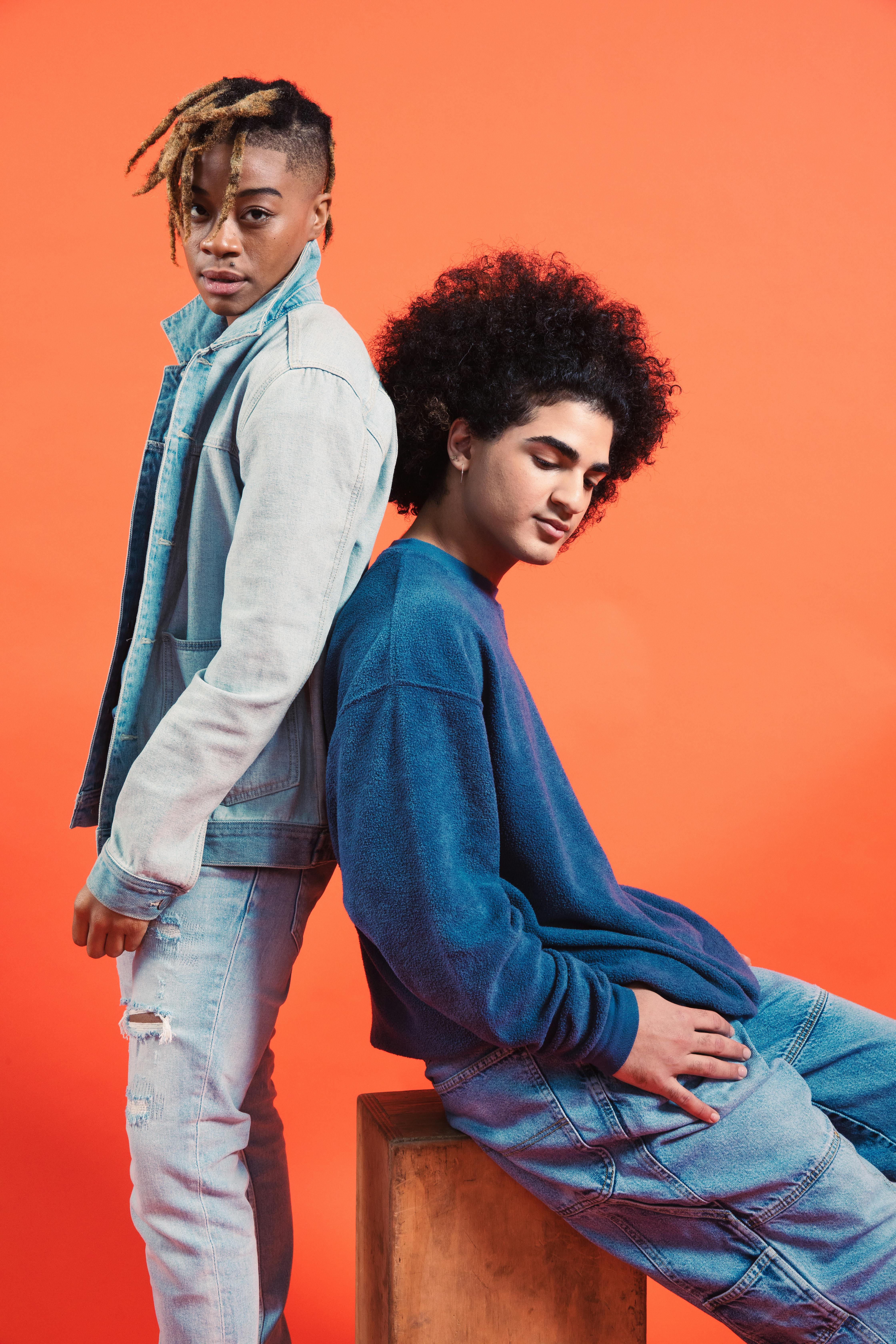 Men Posing Back to Back in Orange Background · Free Stock Photo