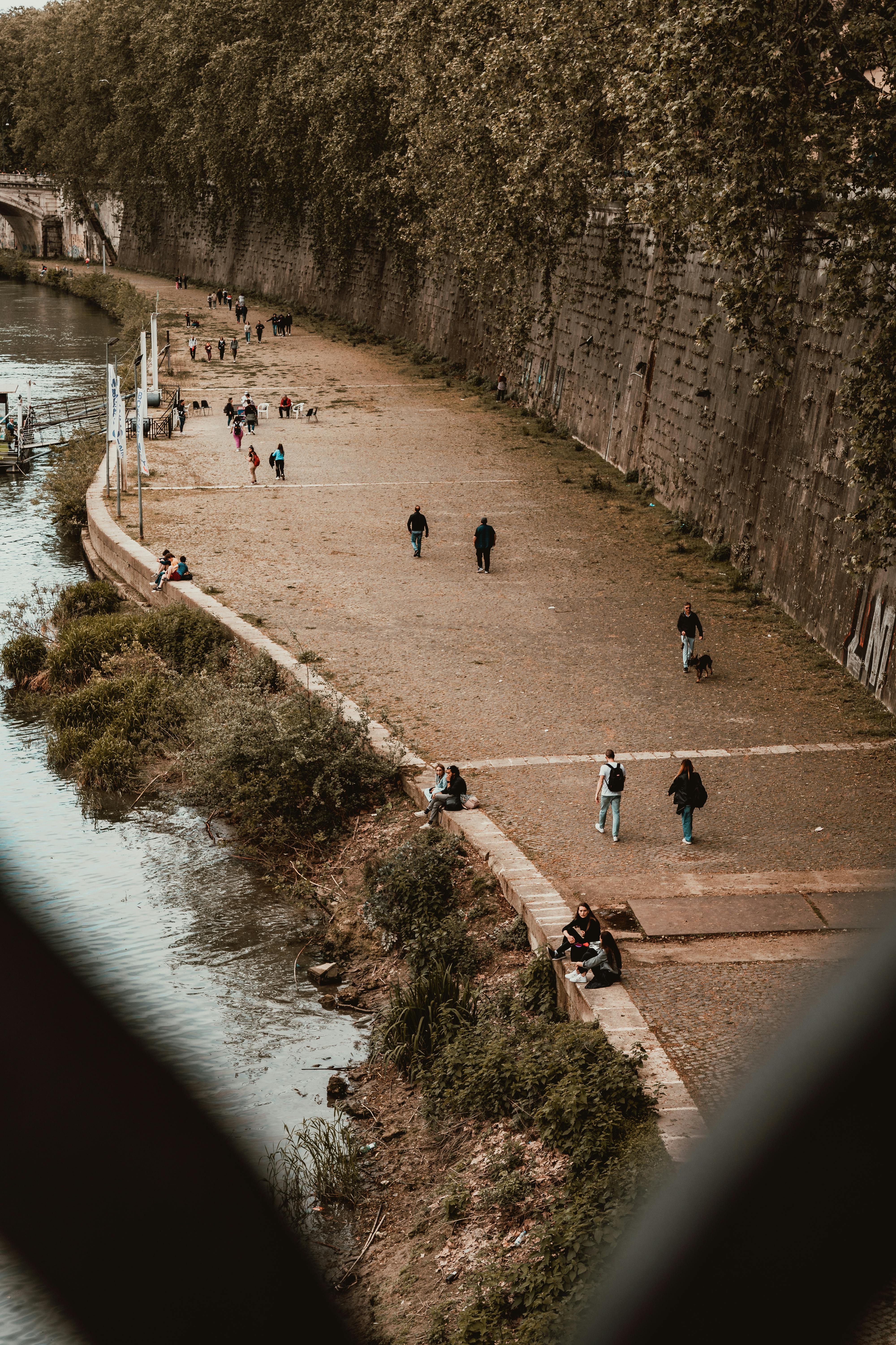 People Walking Along the Riverbank · Free Stock Photo