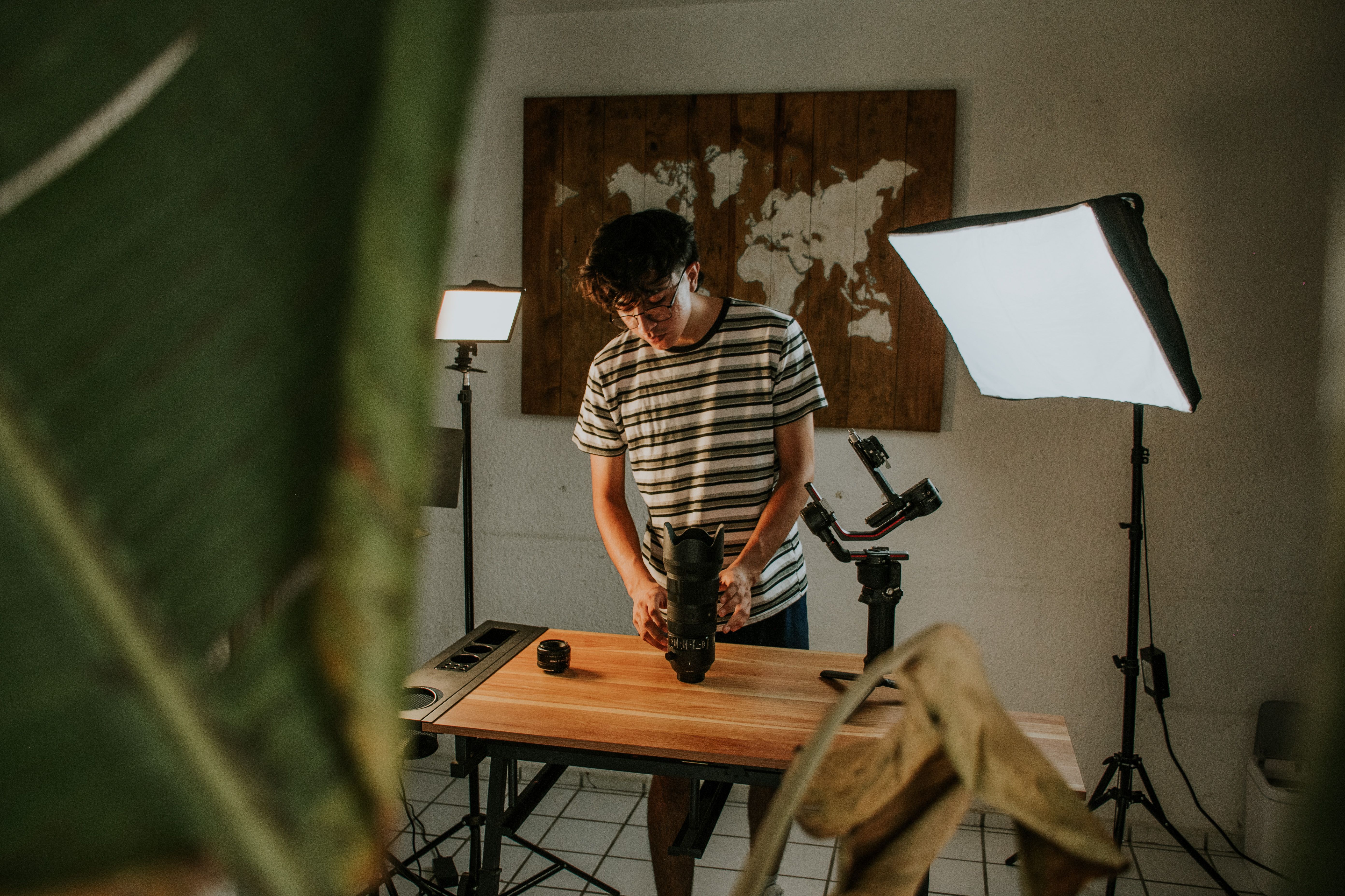 A Man in Striped Shirt Fixing the Camera Lens · Free Stock Photo