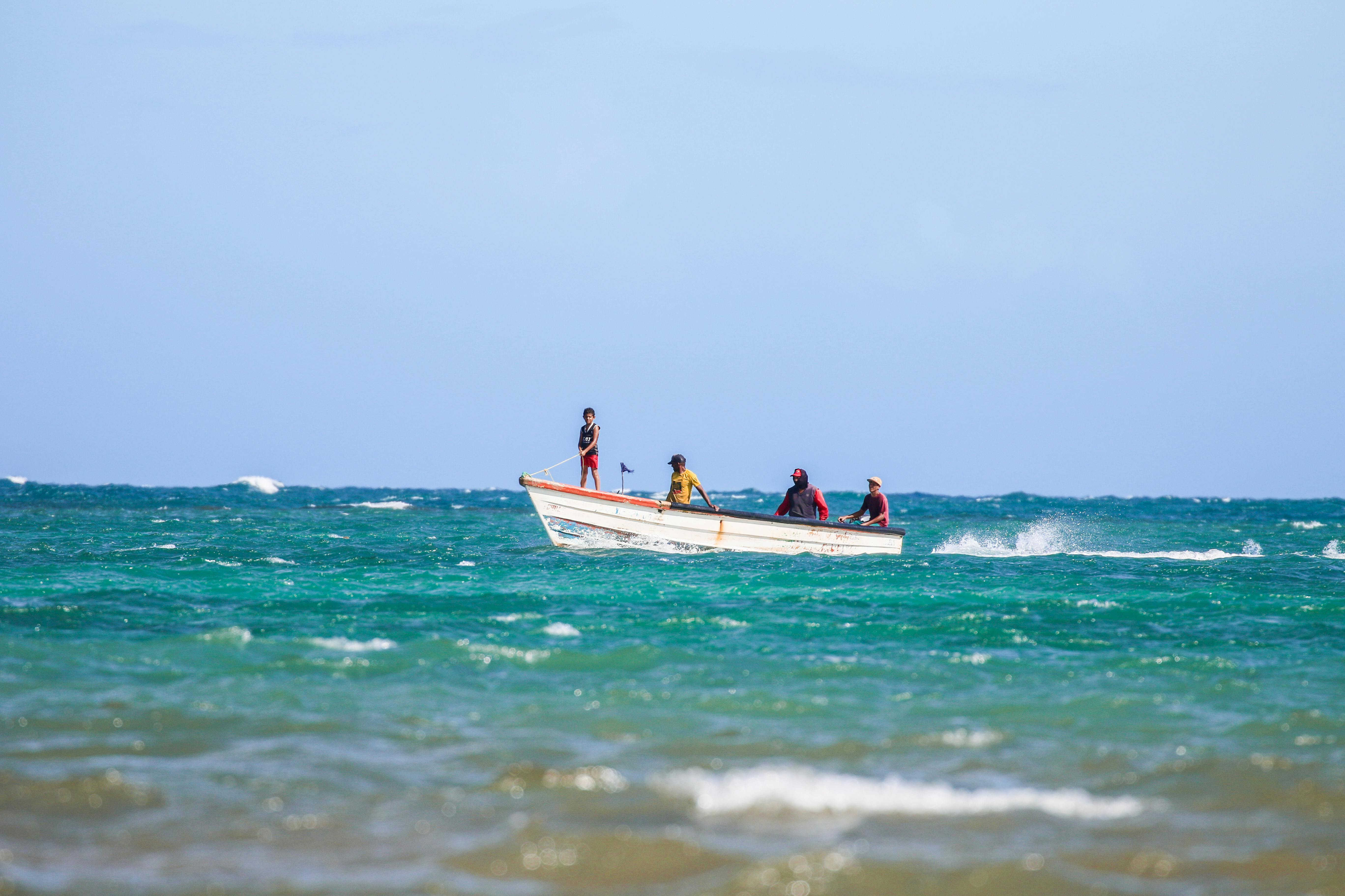 A Back View of a Woman in Bikini Top Sitting on the Boat while Facing ...
