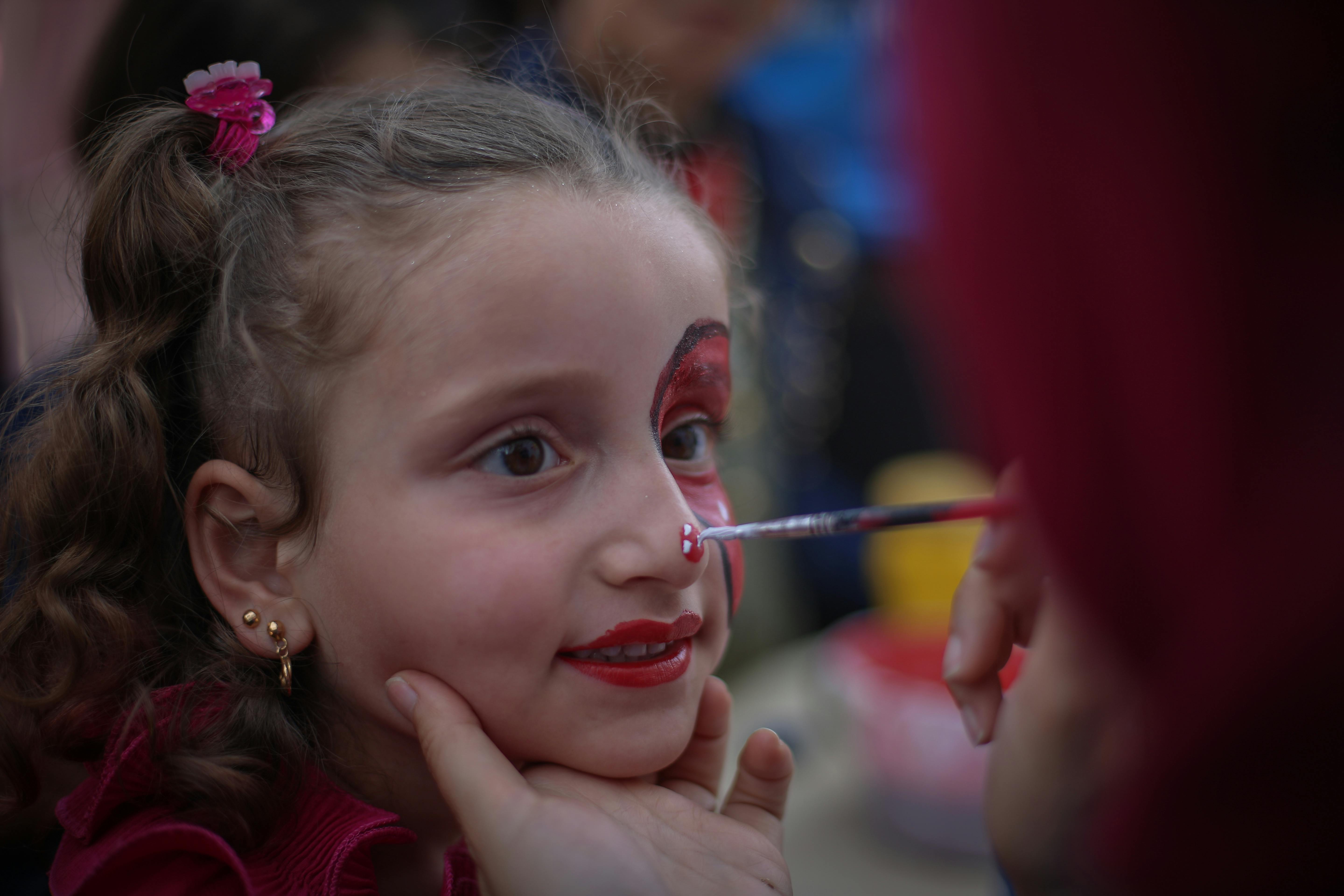 Putting Face Paint on a Beautiful Girl · Free Stock Photo