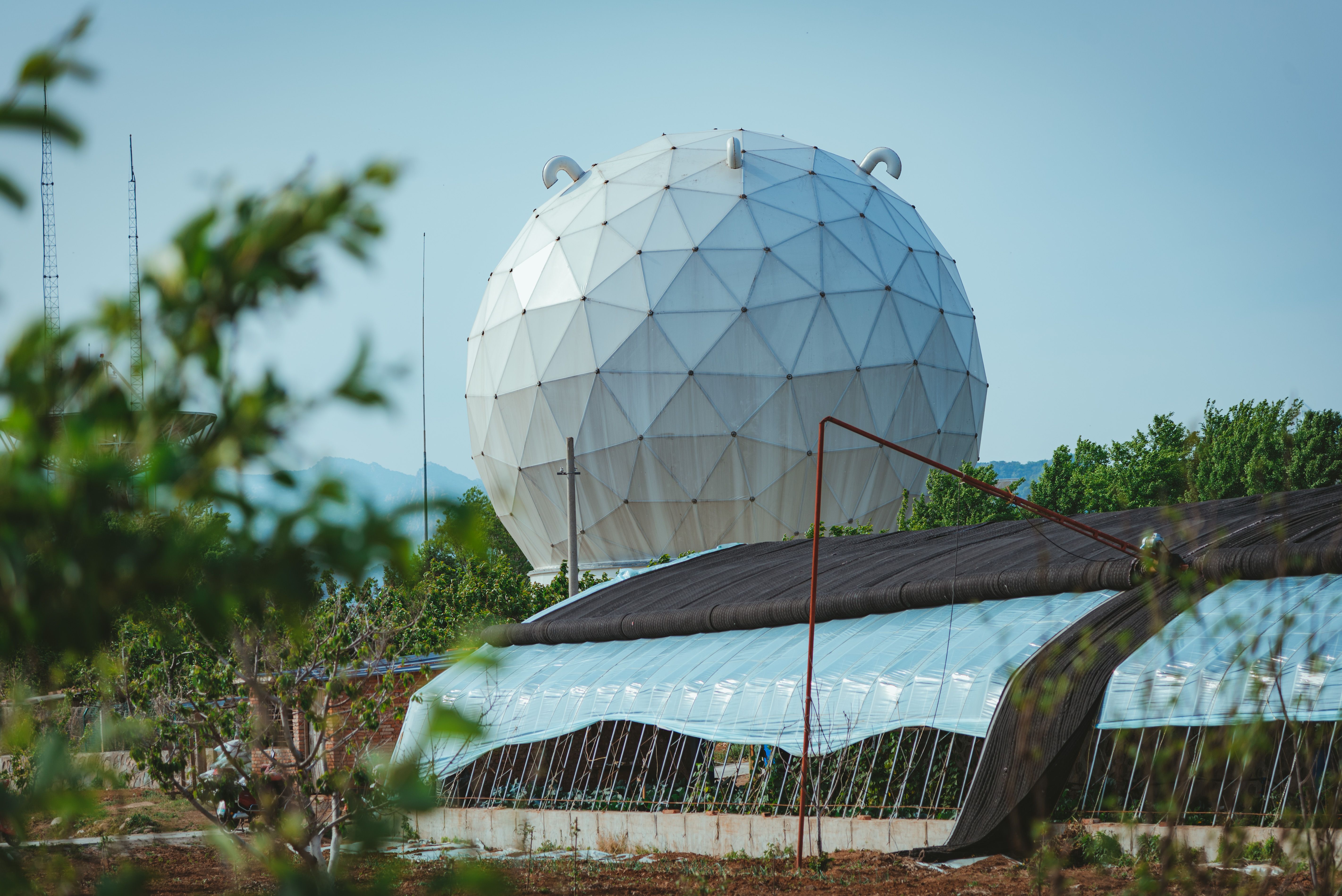 Globe-Shaped Building near Greenhouses · Free Stock Photo