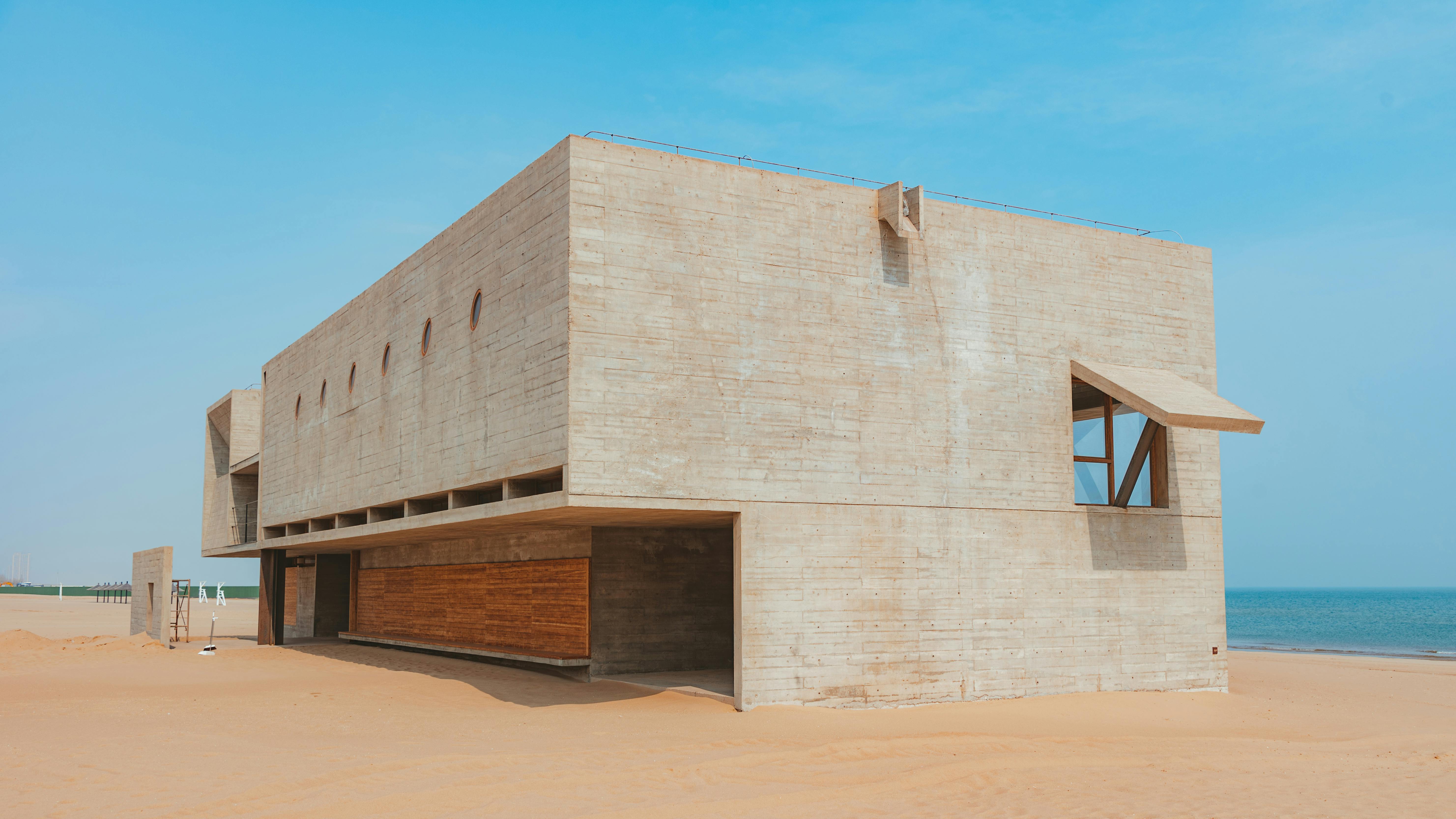Brown Concrete Building on Beach Shore Under Blue Sky · Free Stock Photo