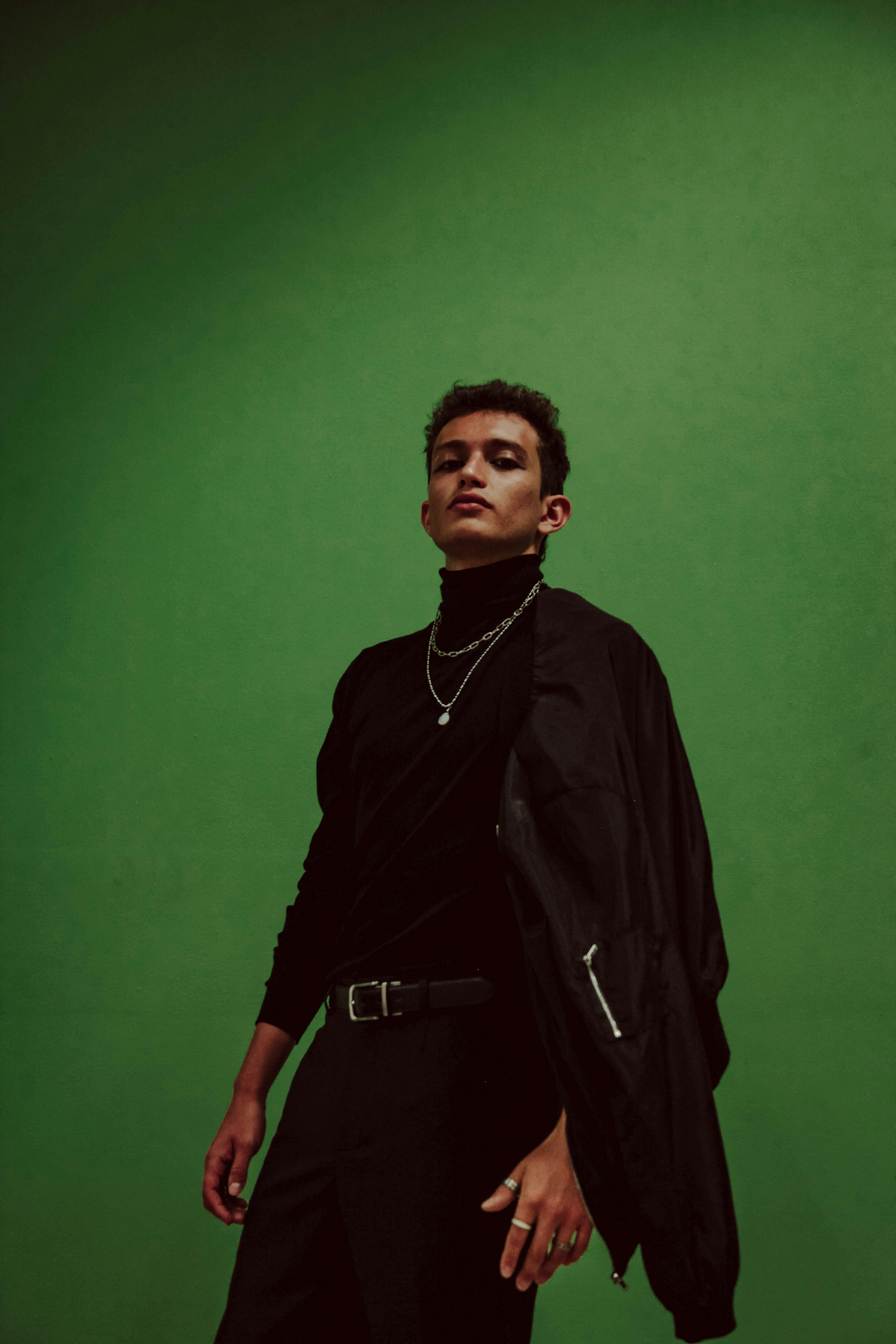 Man in Black Clothes Posing on Green Background · Free Stock Photo